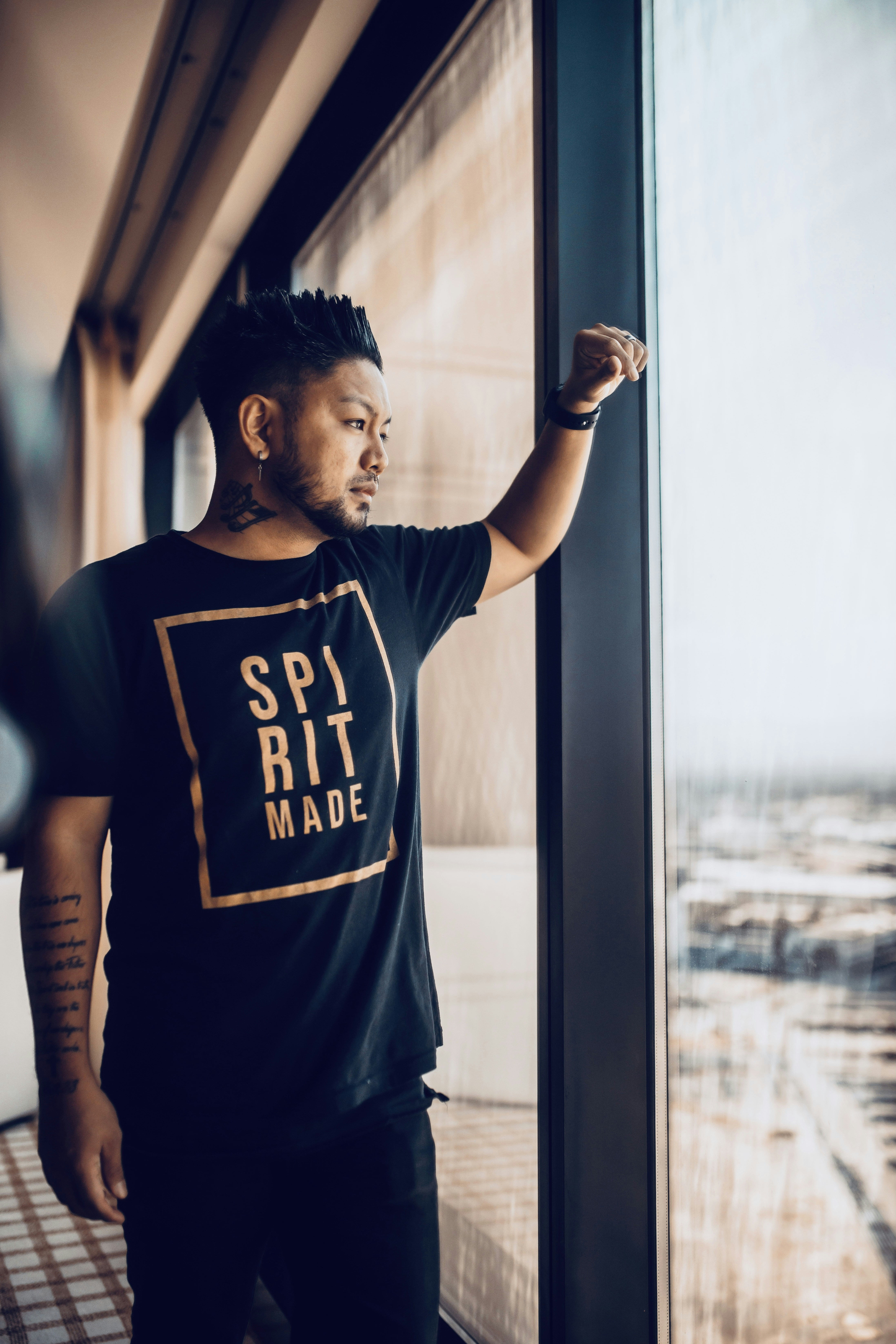 A man standing next to a window looking out at the ocean photo – Free Chrisitan Image on Unsplash