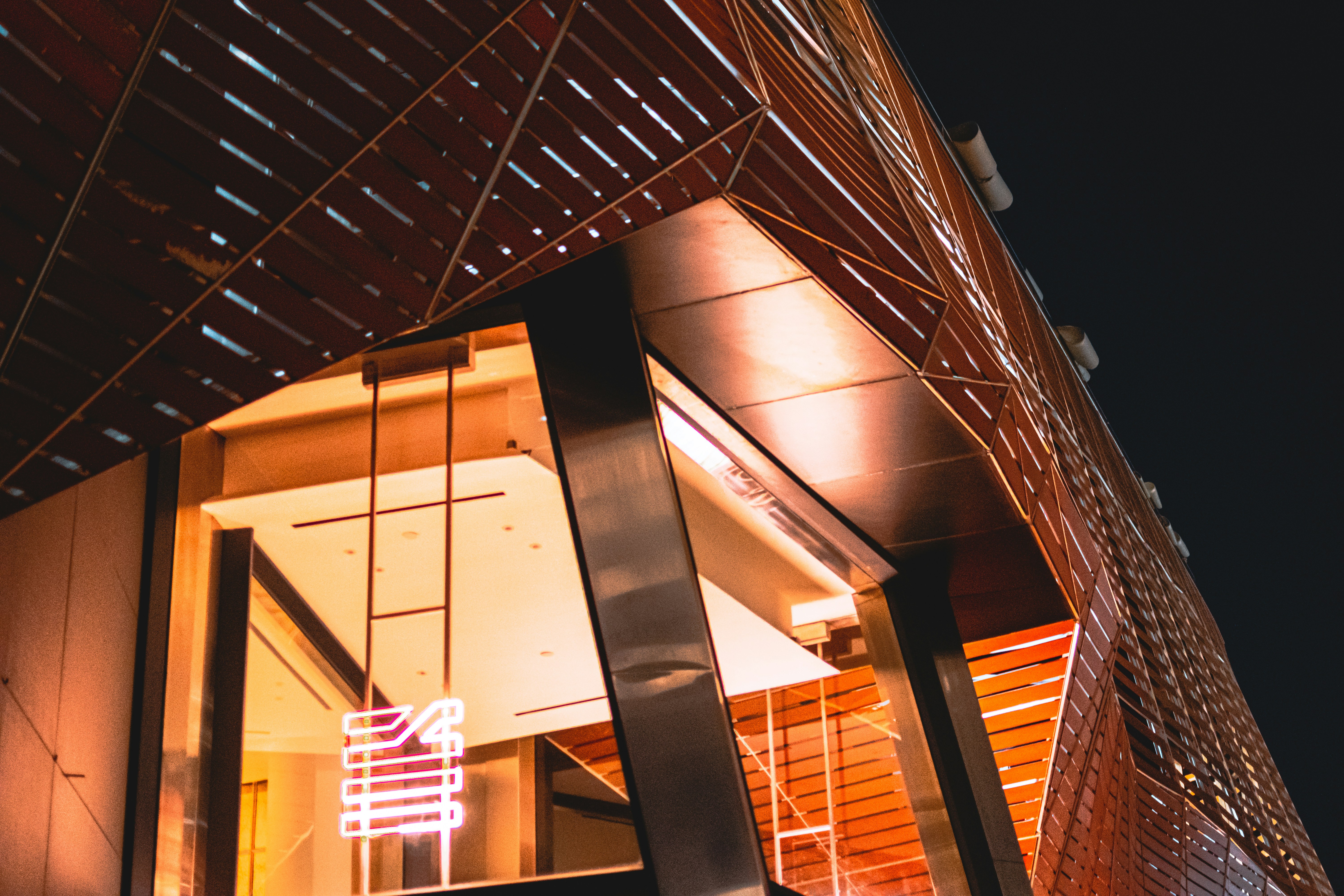 Foto Un edificio alto con un letrero iluminado en su costado – Imagen ...