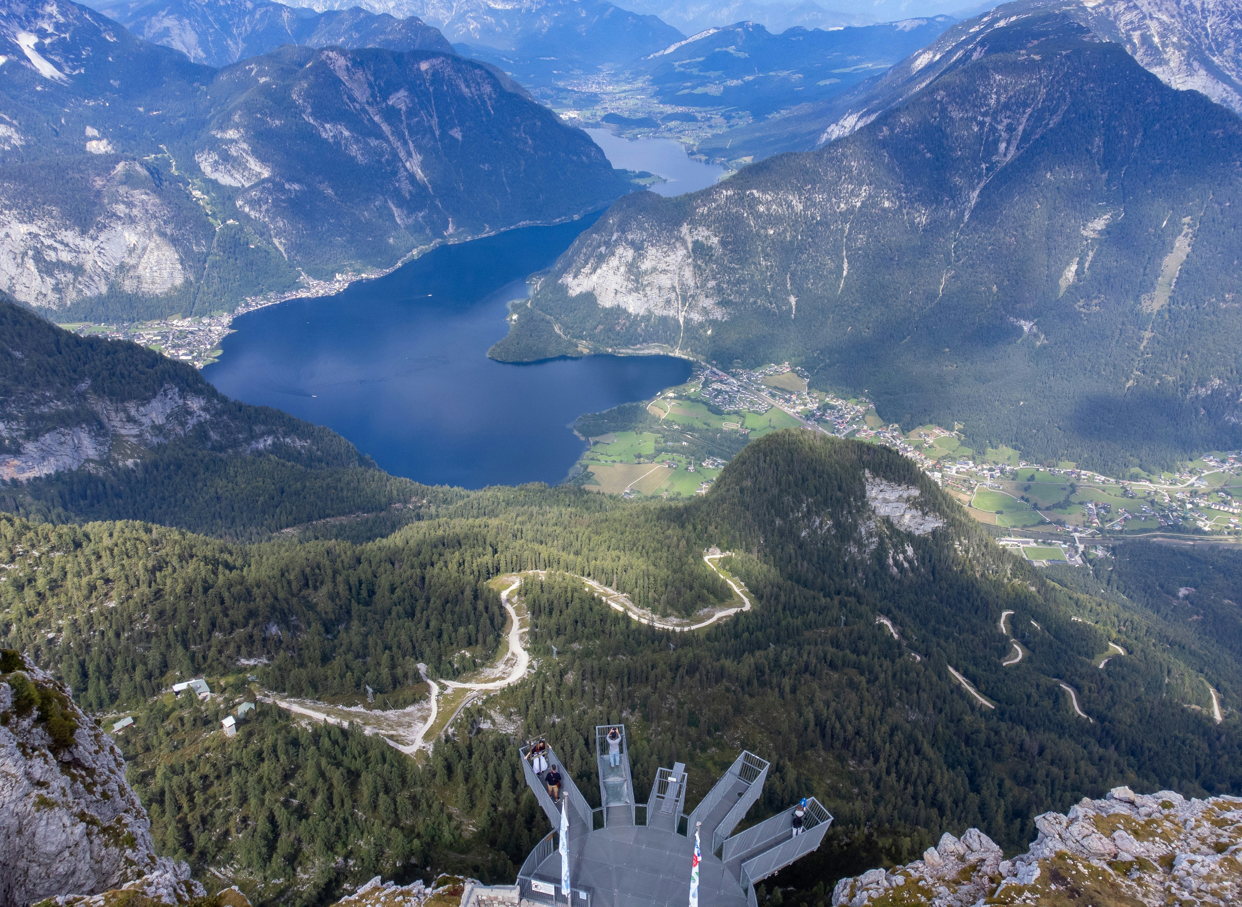 A view from the top of a mountain looking down at a lake and mountains ...