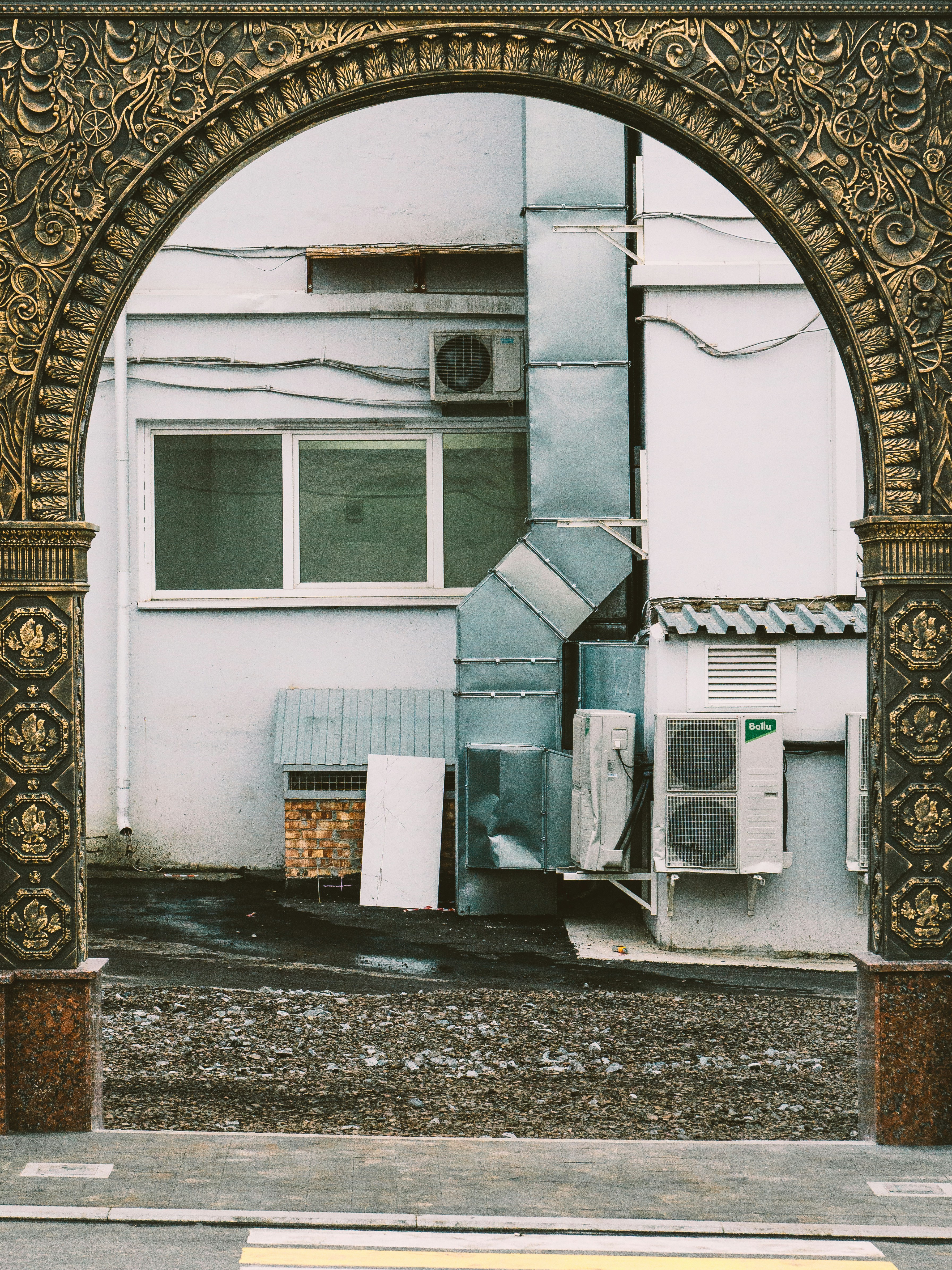 Hidden Mechanical Alley Framed by Ornate Arch