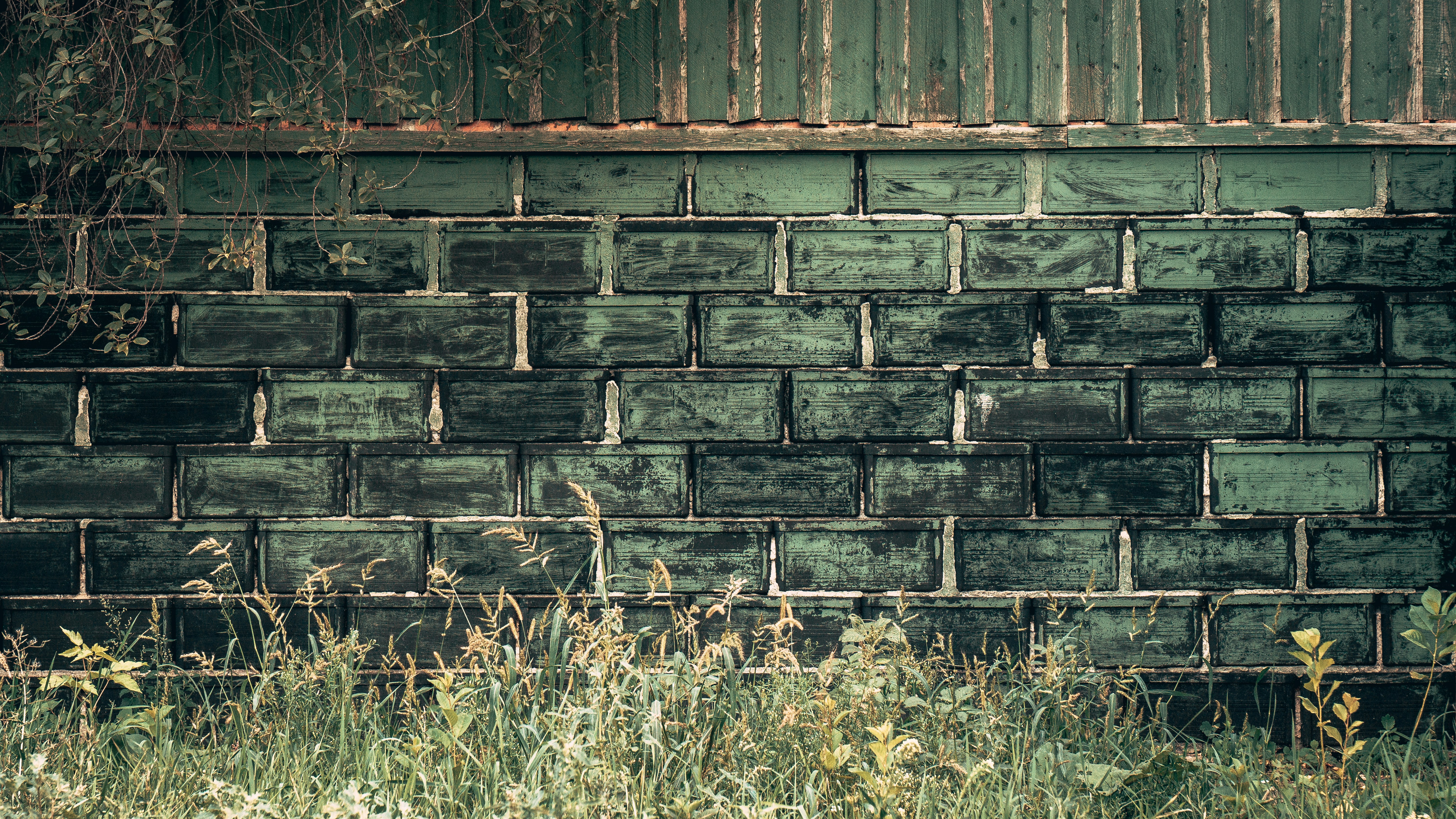 Weathered Brick Boundary: Encroaching Grass at the Wall's Base