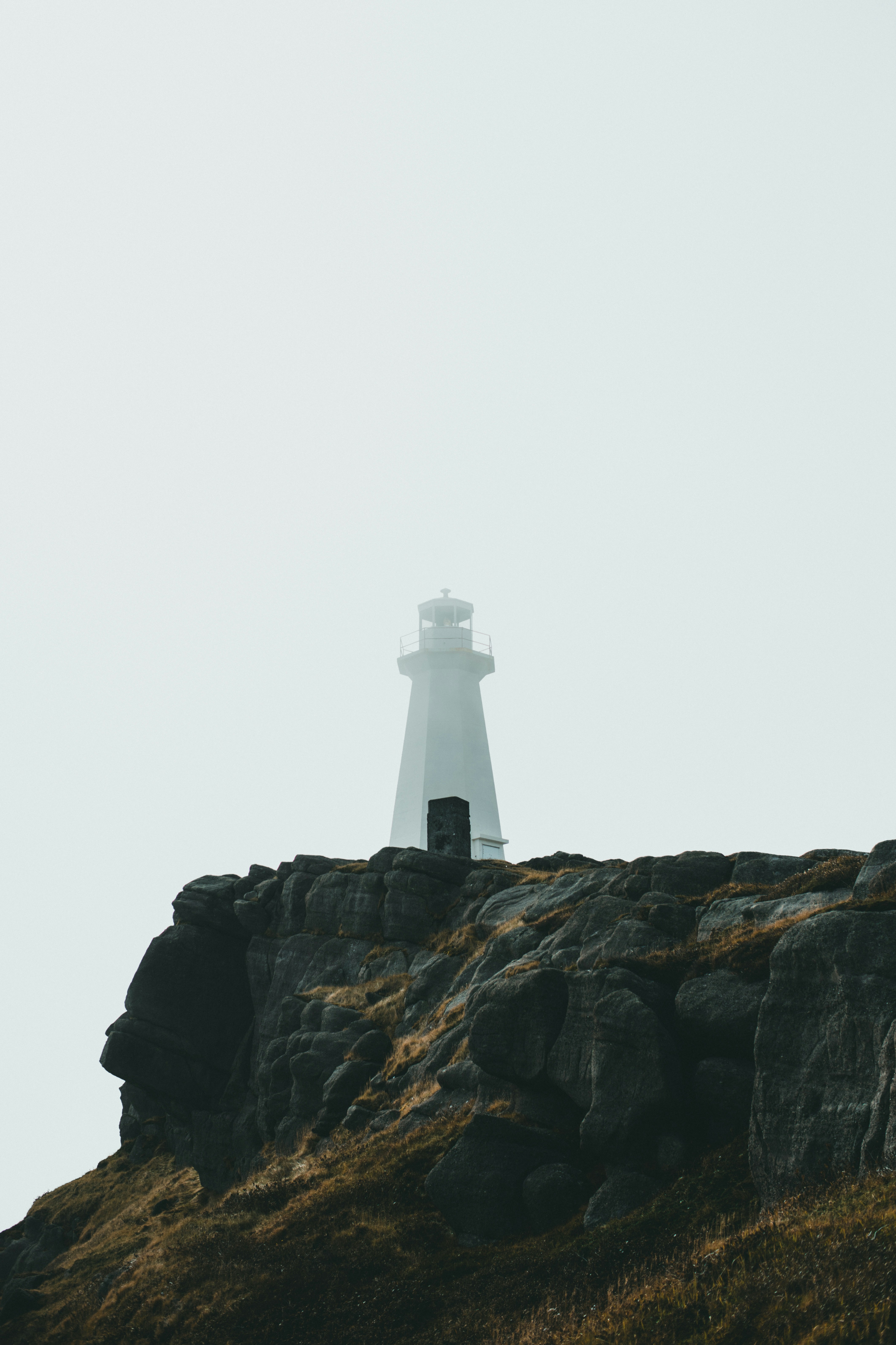 A lighthouse on top of a rocky cliff photo – Free Building Image on ...