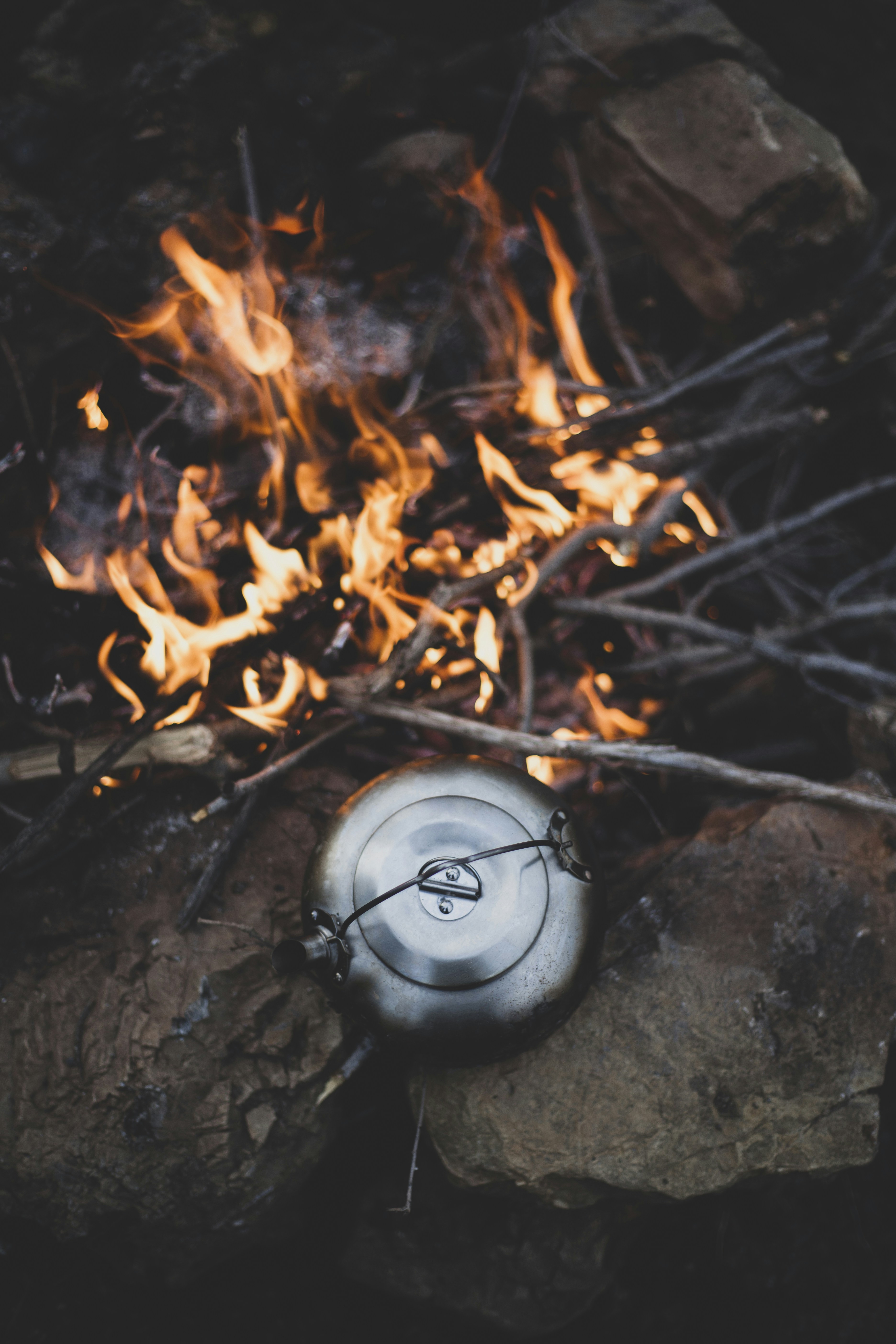 A white frisbee sitting on top of a rock next to a fire photo – Free ...