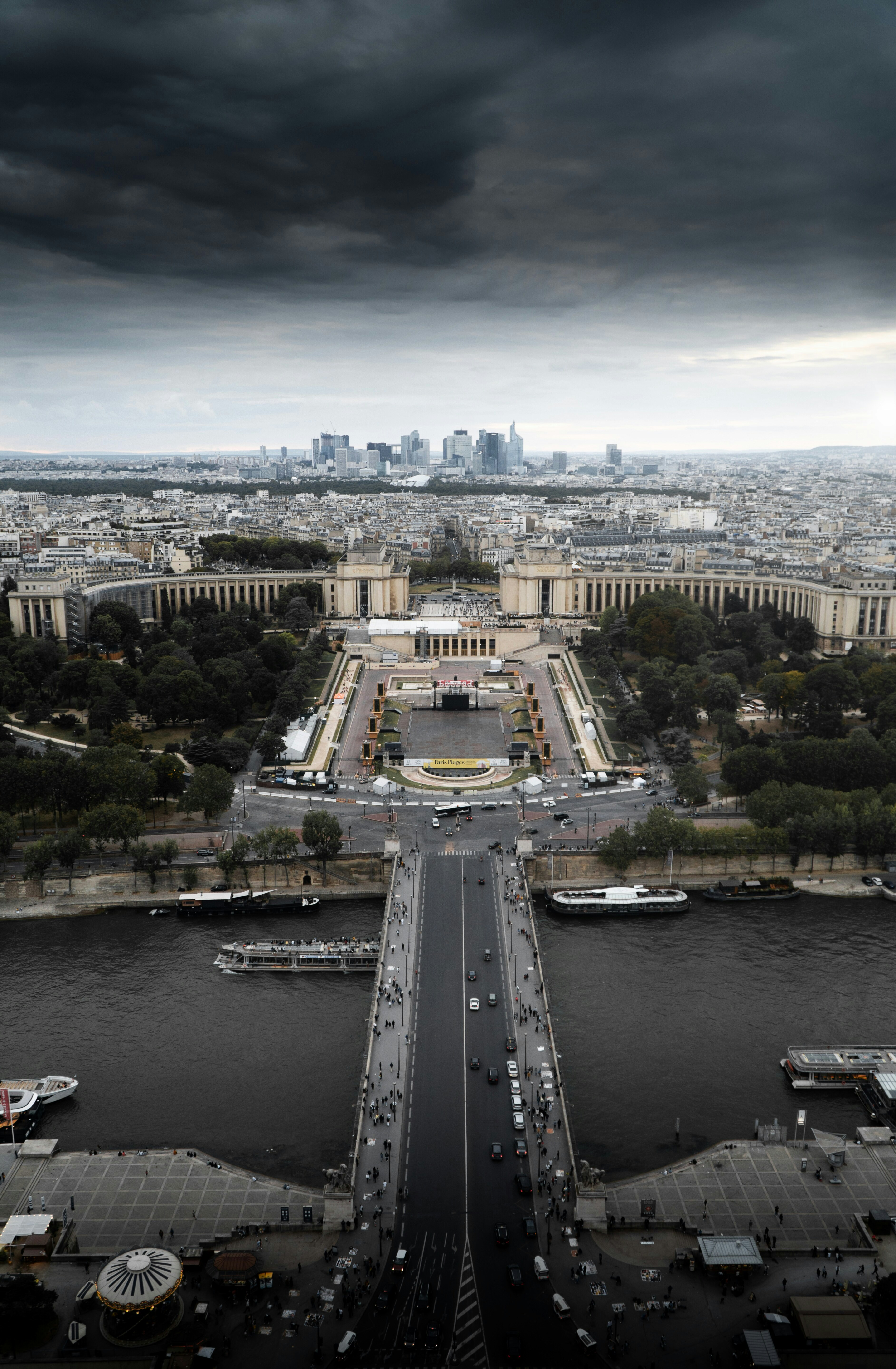 Seine's Spine: A Bridge Toward Paris' Distant Skyline Under Storm Clouds