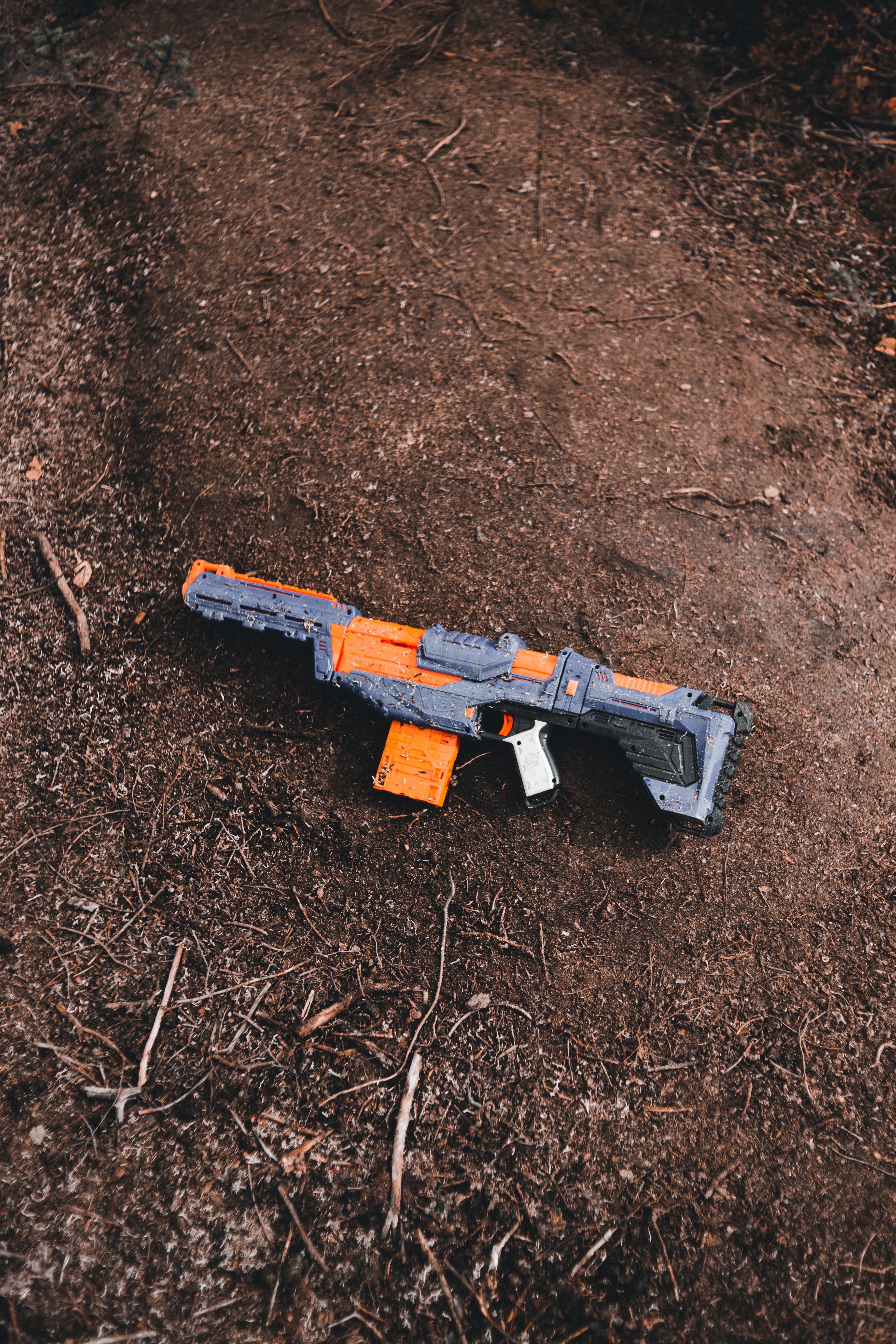 A toy gun laying on the ground in the dirt photo – Free Soil Image on ...