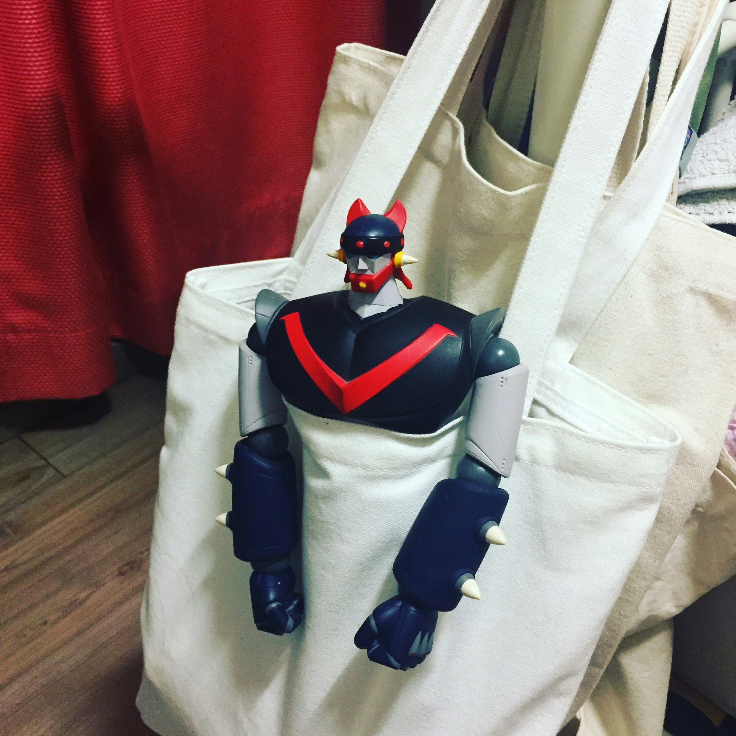 Pocket Sentinel: A Bold Robot Figurine Peers from a Tote Bag