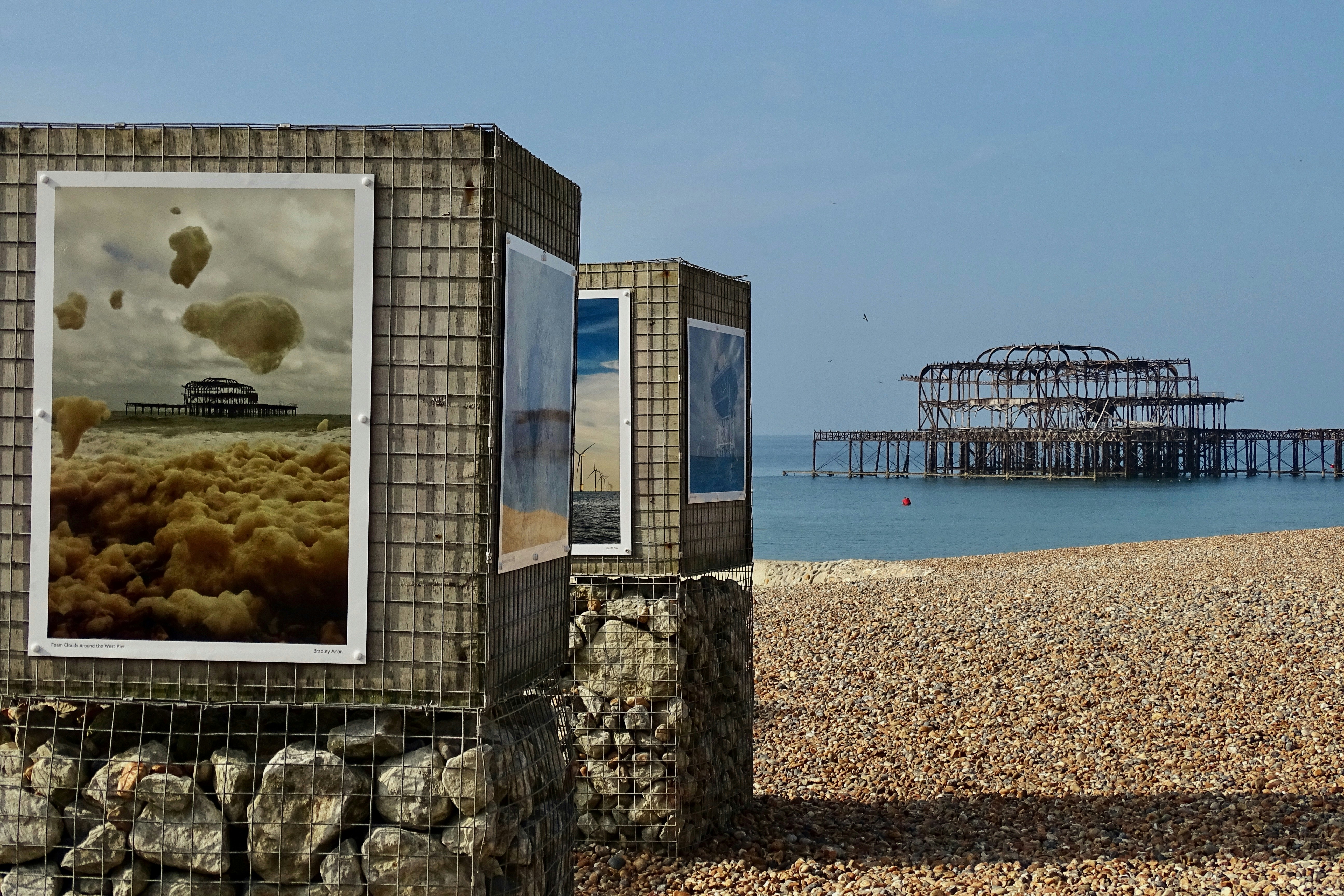 Posters on a Breakwater: A Pebble-Beach Composition by the Sea's Distant Skeleton