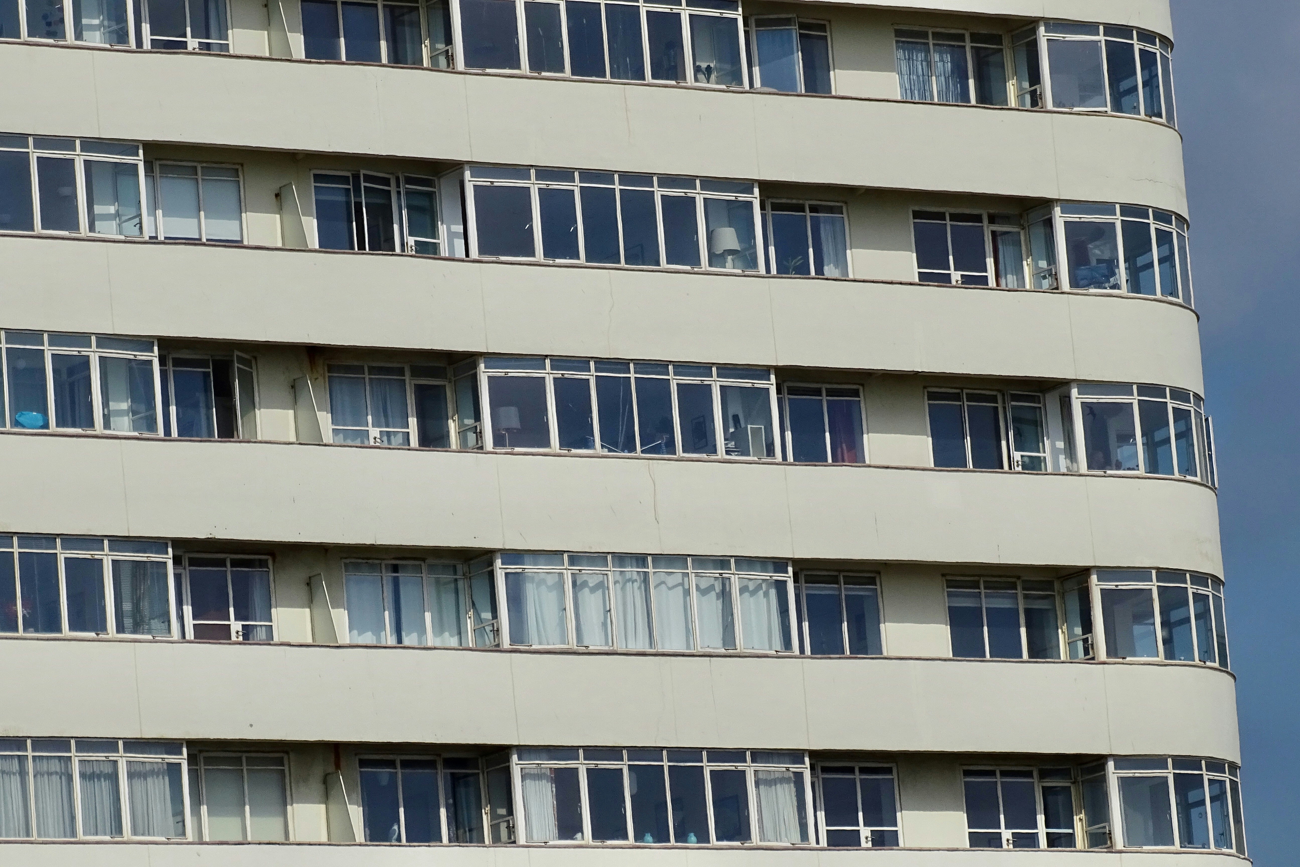 Close-up view of a modern building facade showcasing a rhythmic arrangement of windows and curtains.