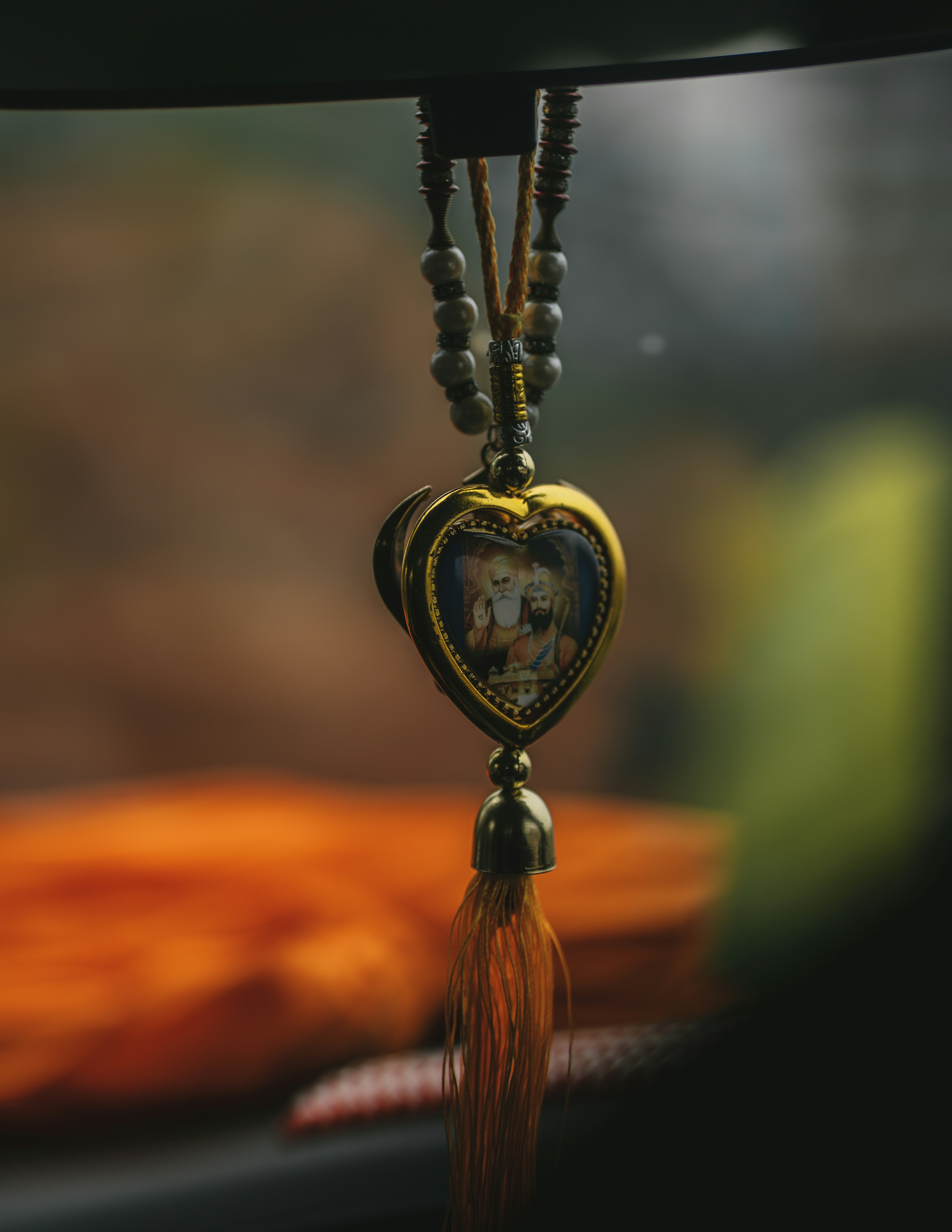Heart Locket on Beads: Quiet Glow through a Car Window