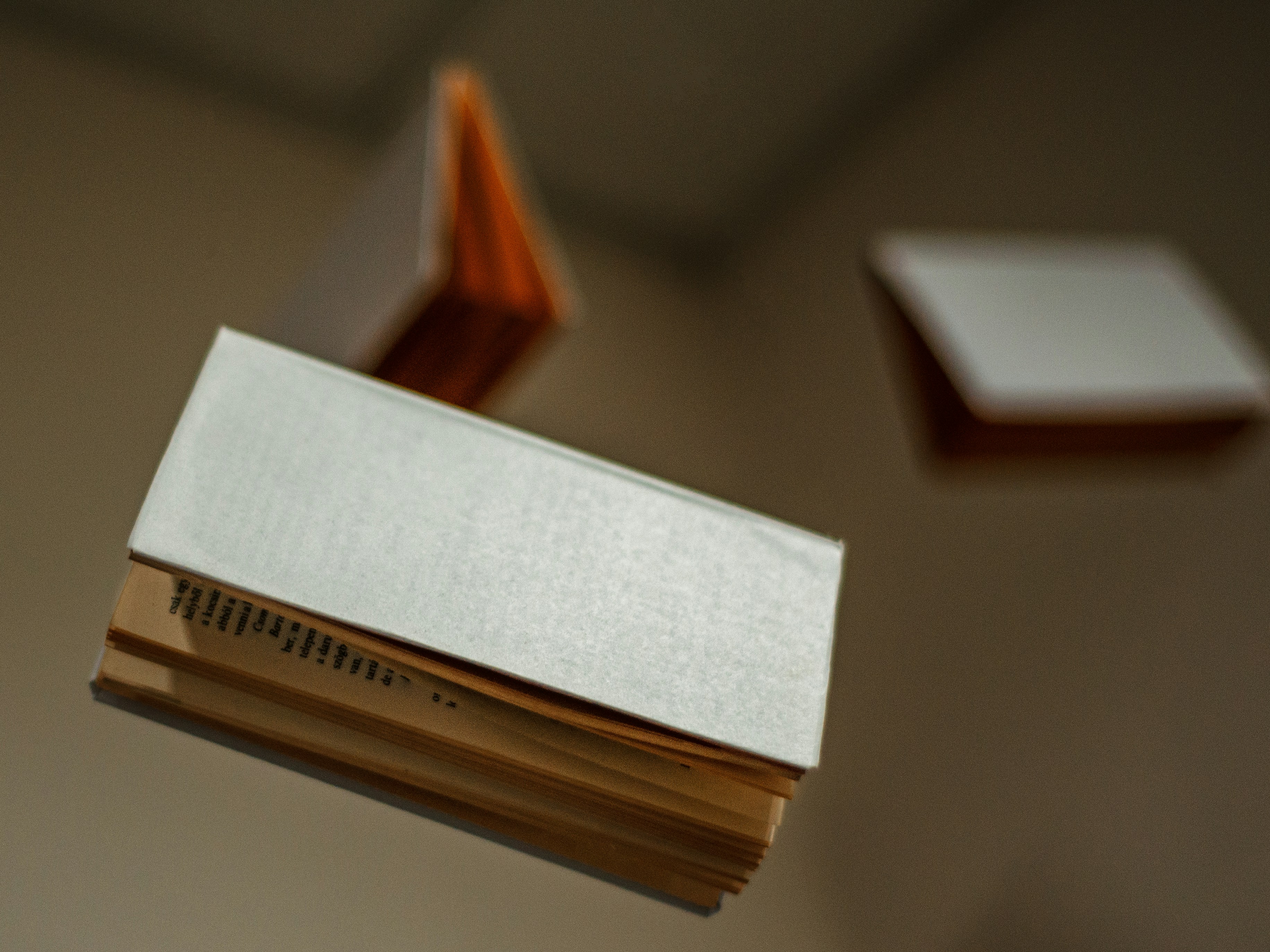 Books suspended mid-air against a muted background, creating a surreal floating effect.