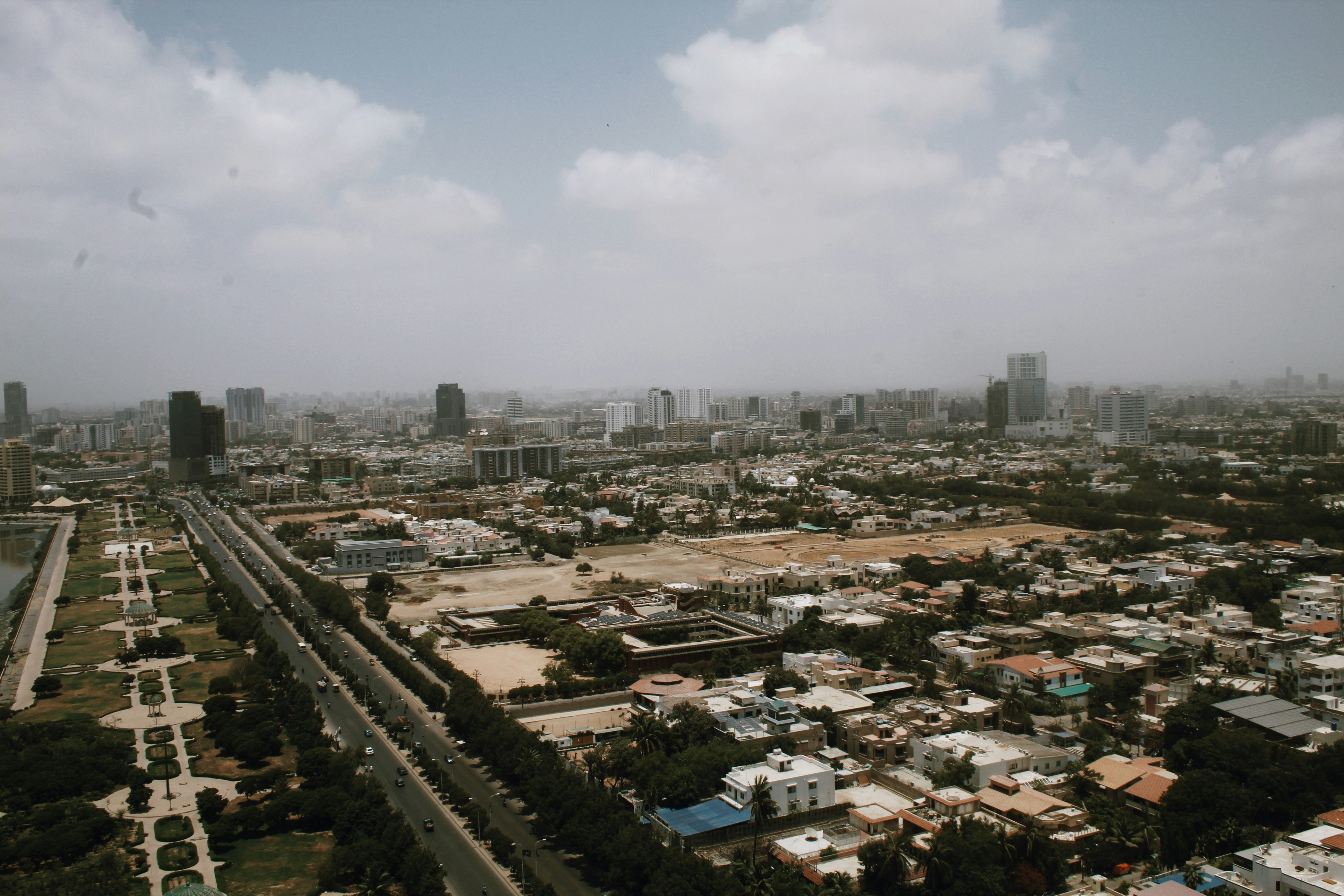 Aerial view of a bustling urban landscape showcasing a blend of modern skyscrapers and residential areas under a cloudy sky.