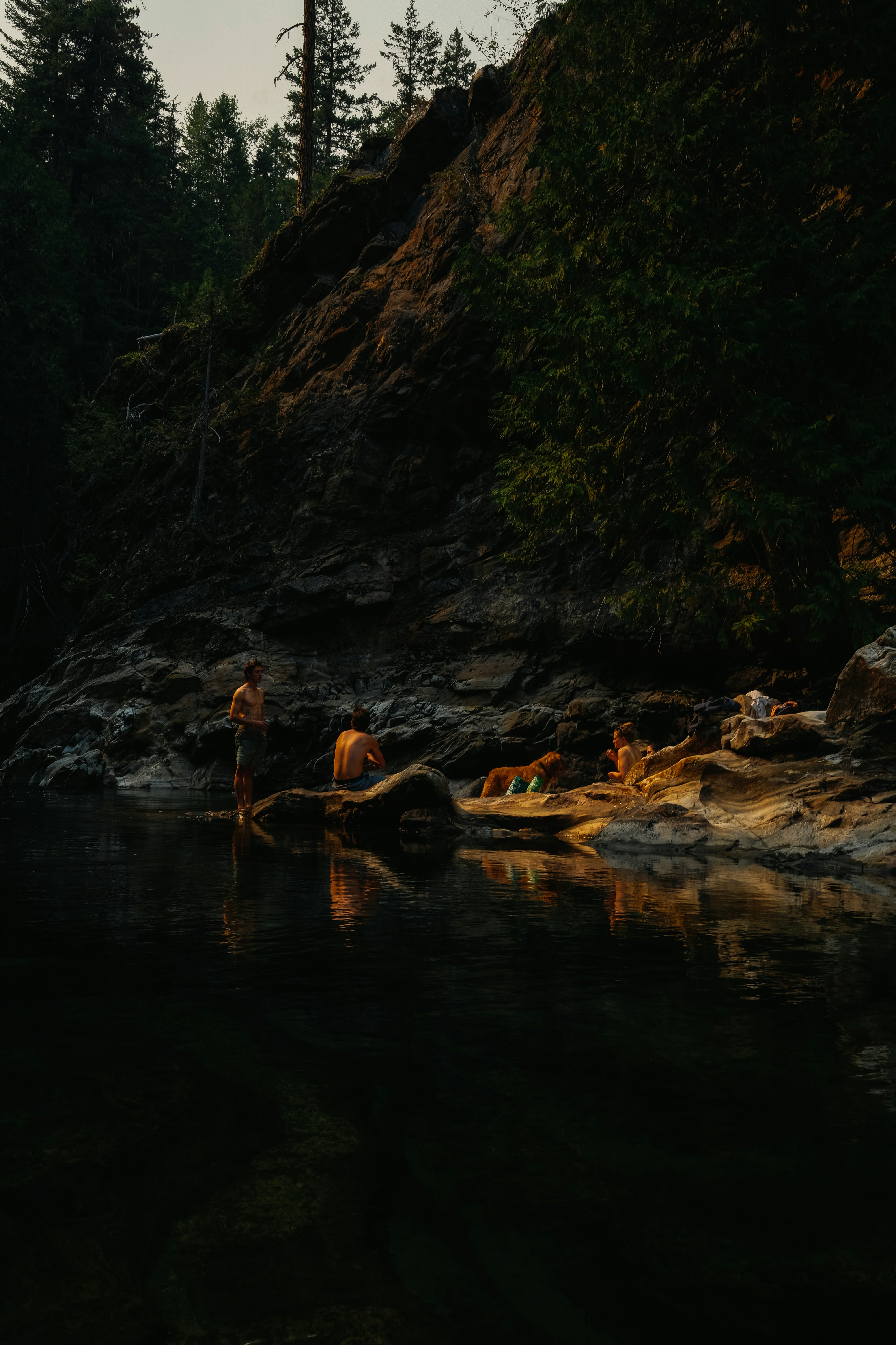 Friends enjoying afternoon light above waterfall. 