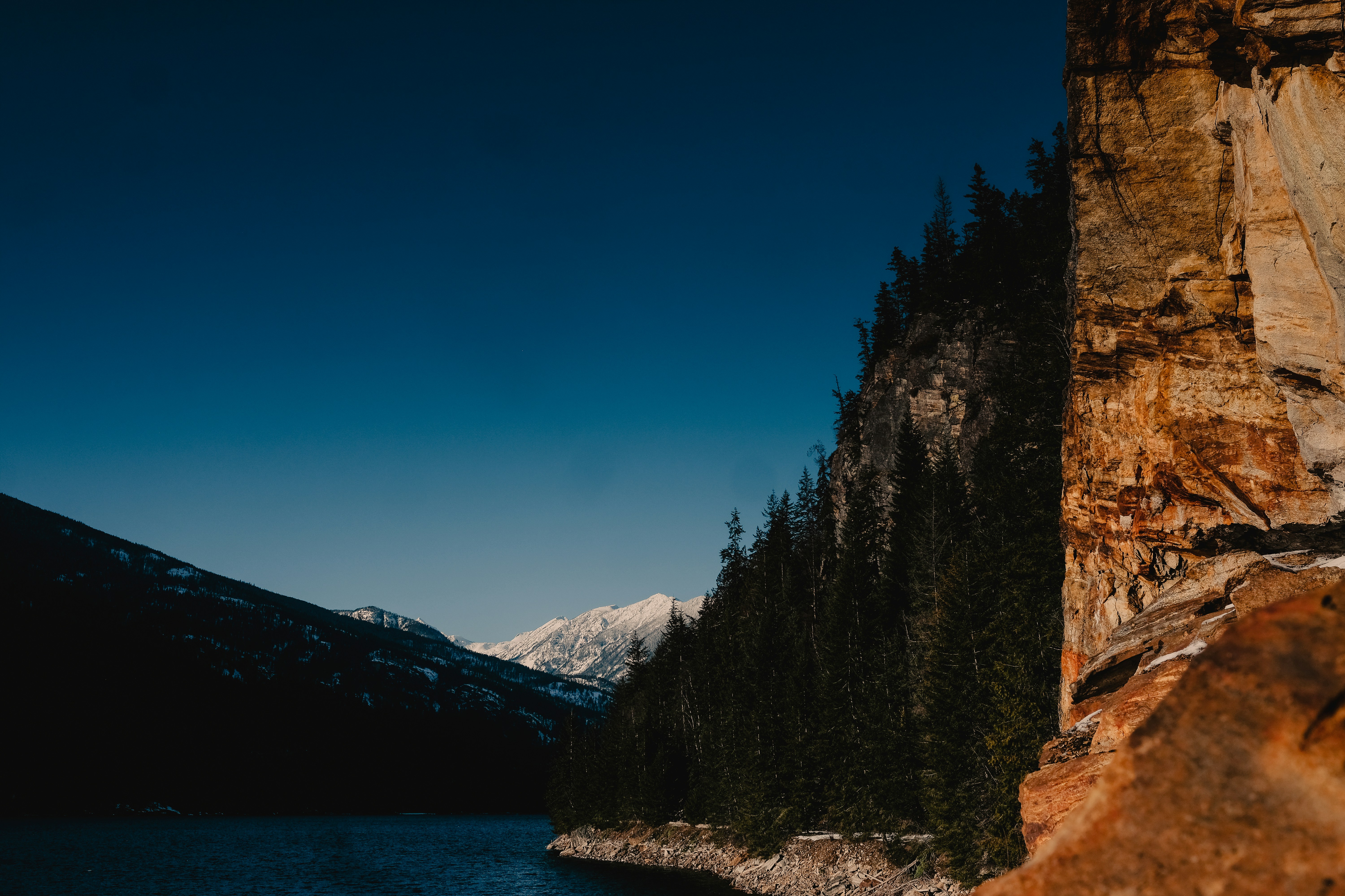 Snowy Peak Reflections Beyond a Cliff-lined Shore