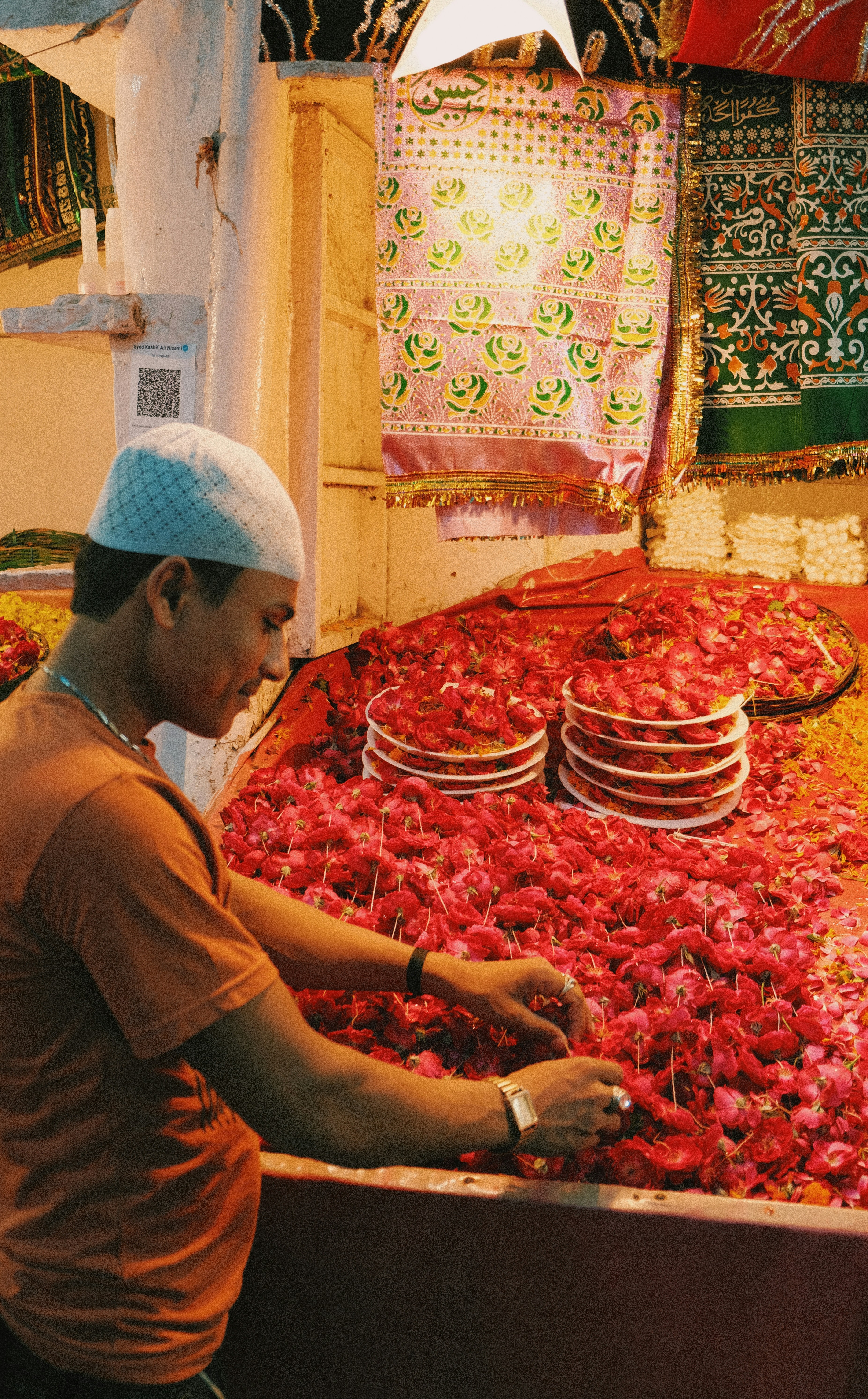 Hands of the Petal Trader Beneath a Textile Rainbow