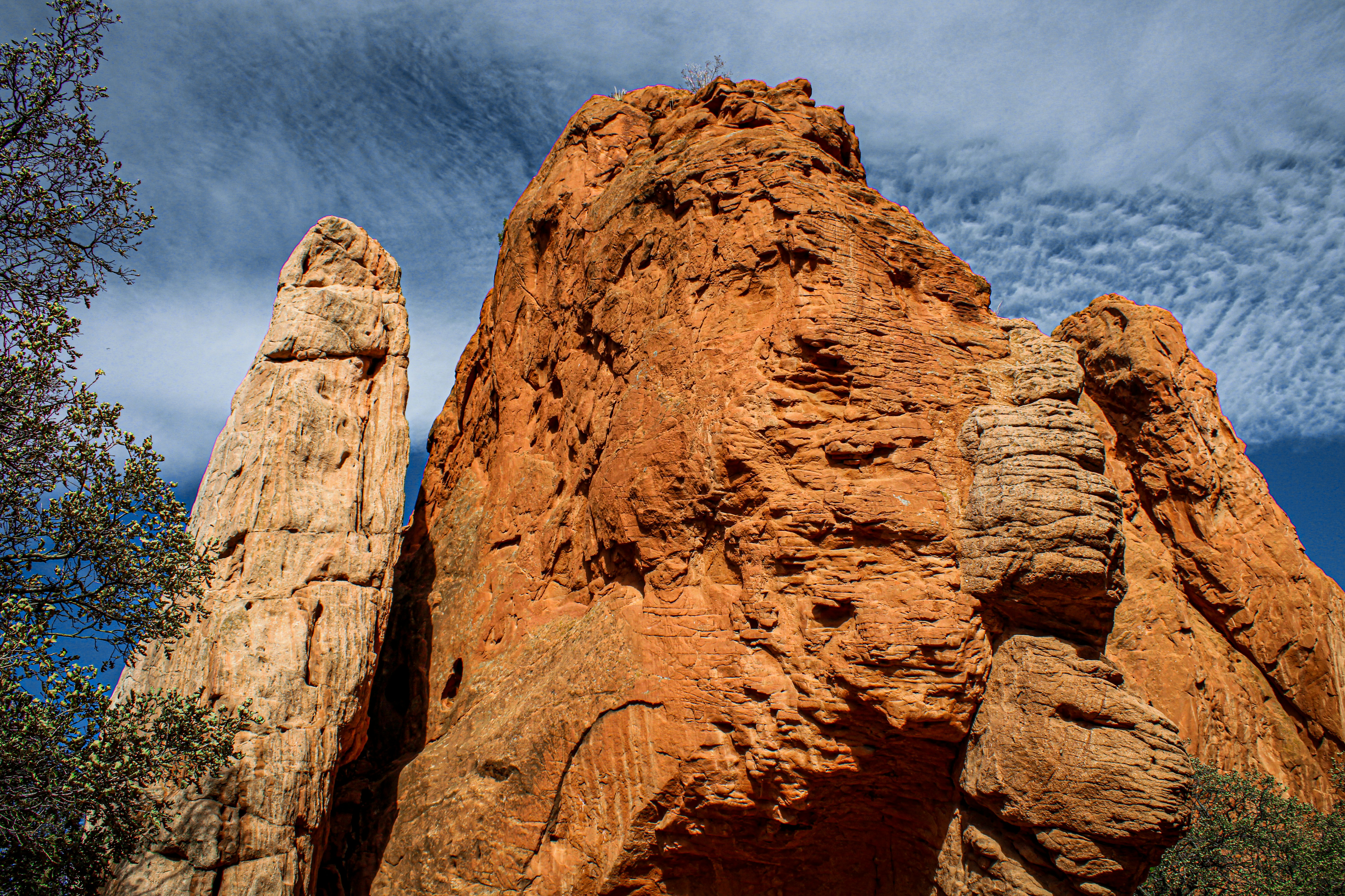 A tall rock formation with a blue sky in the background photo – Free ...