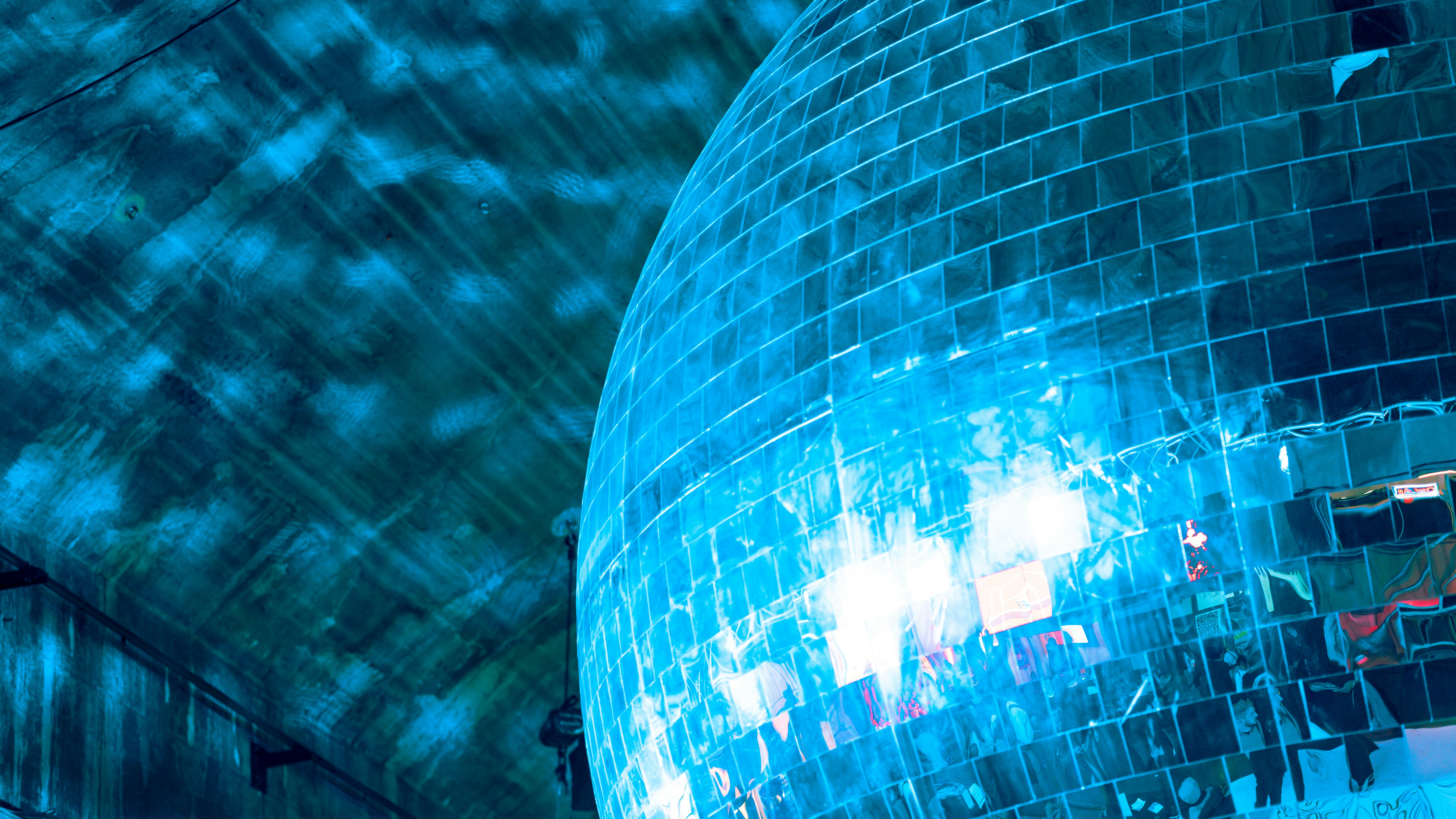 Neon-Turquoise Mosaic Sphere Reflecting a Neon-Glow Ceiling