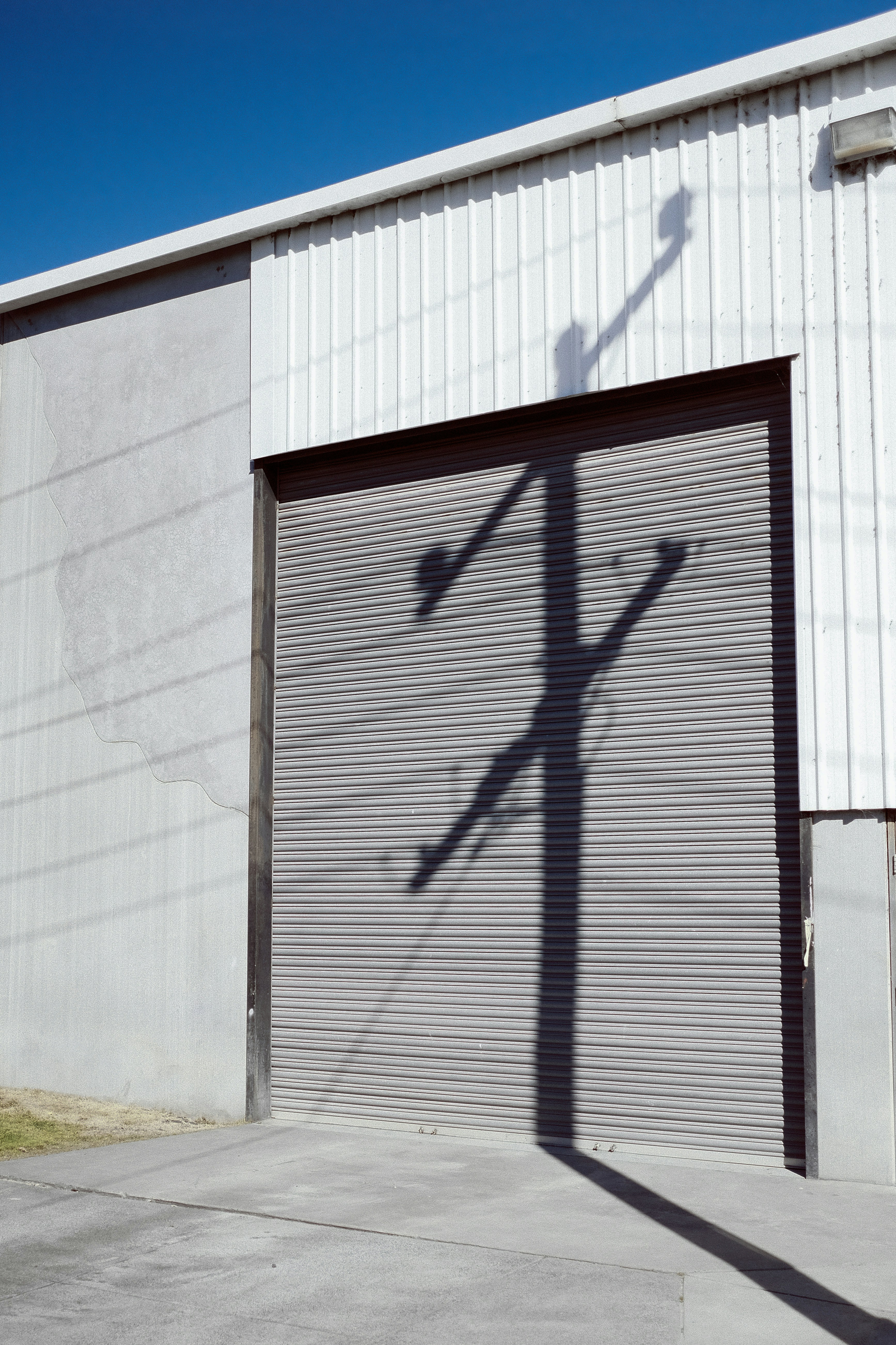 the shadow of a street light on a garage door