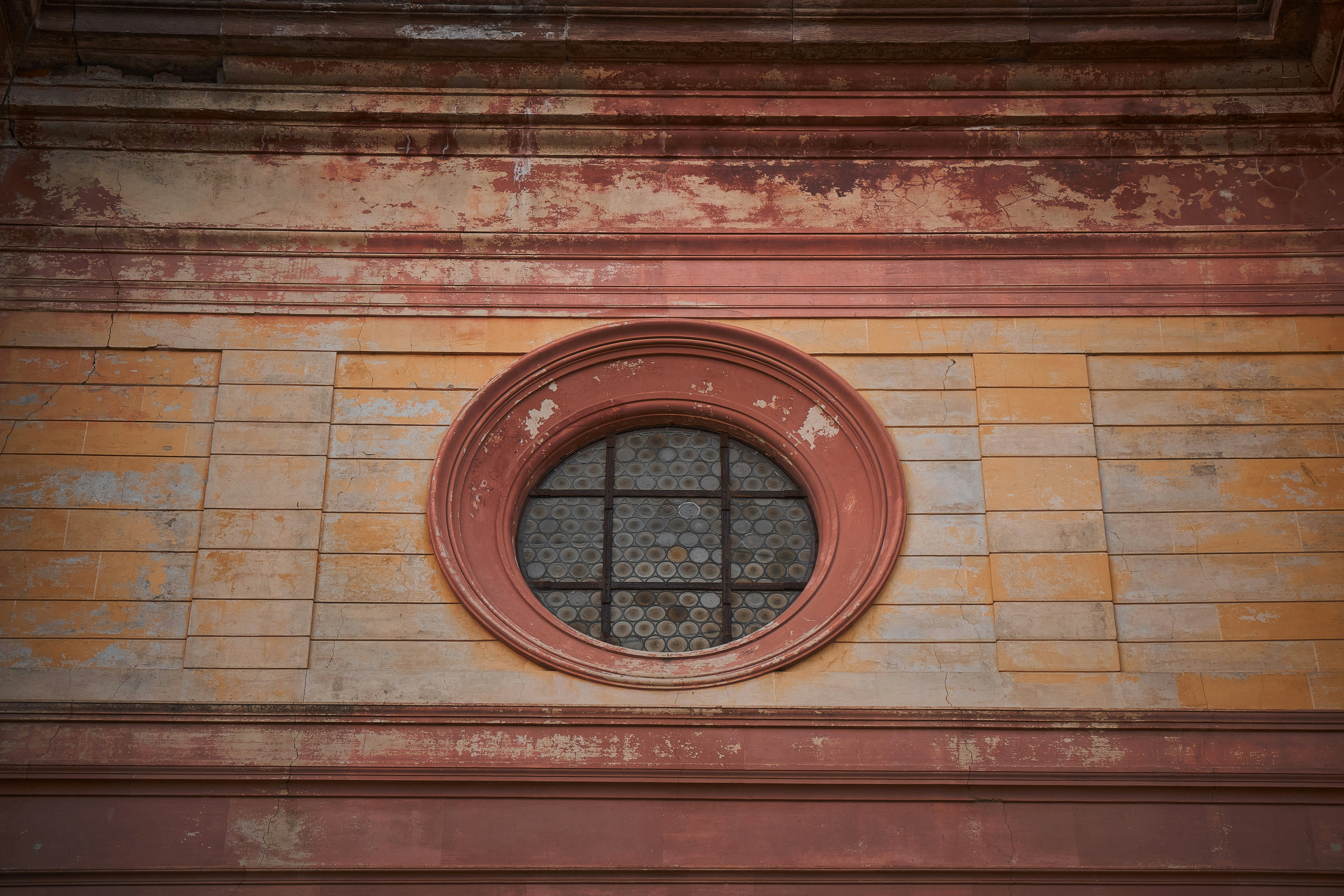 Circular window in weathered brickwork: a quiet architectural vignette