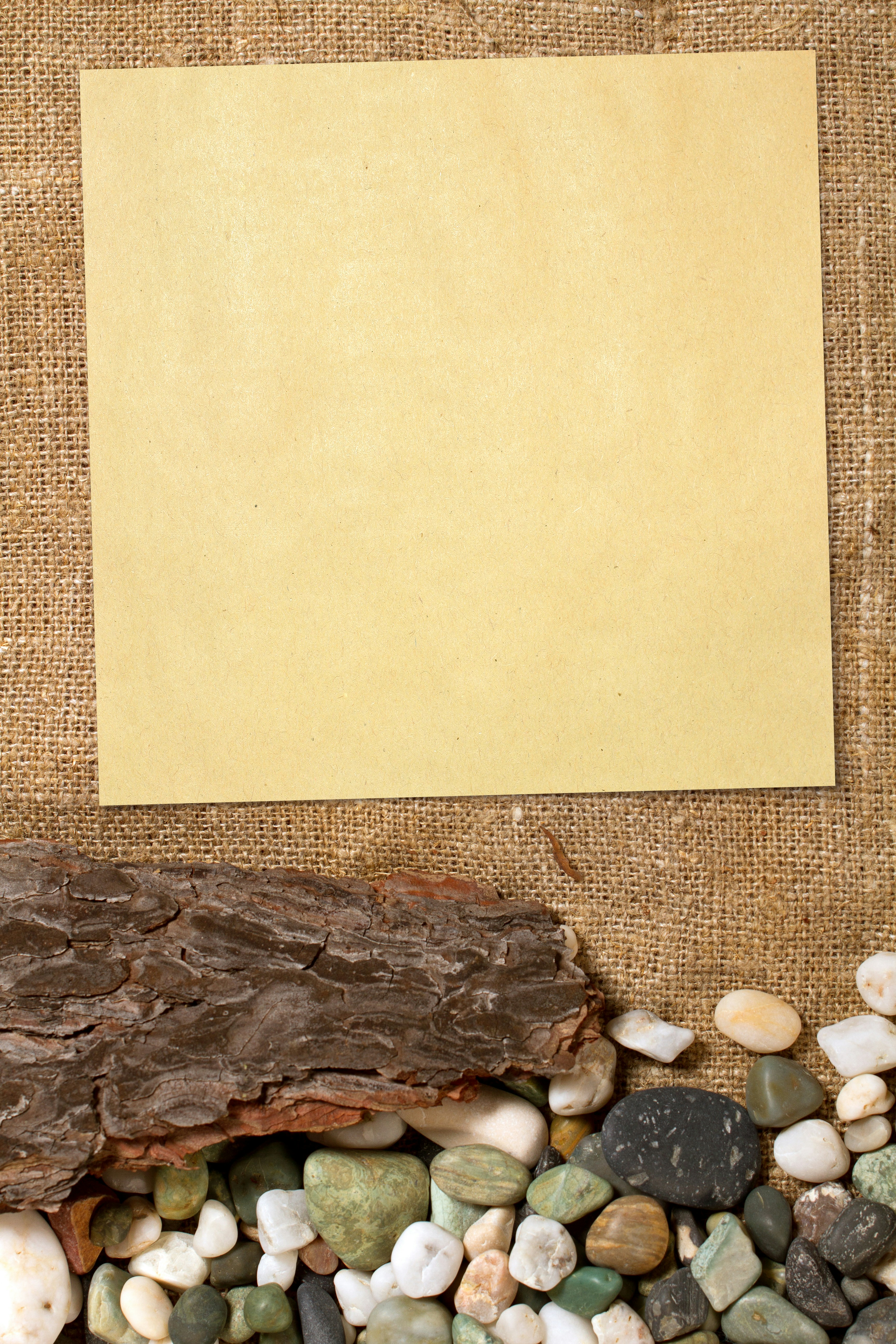 Yellow Post-It Pauses a Pebble Parade on Burlap