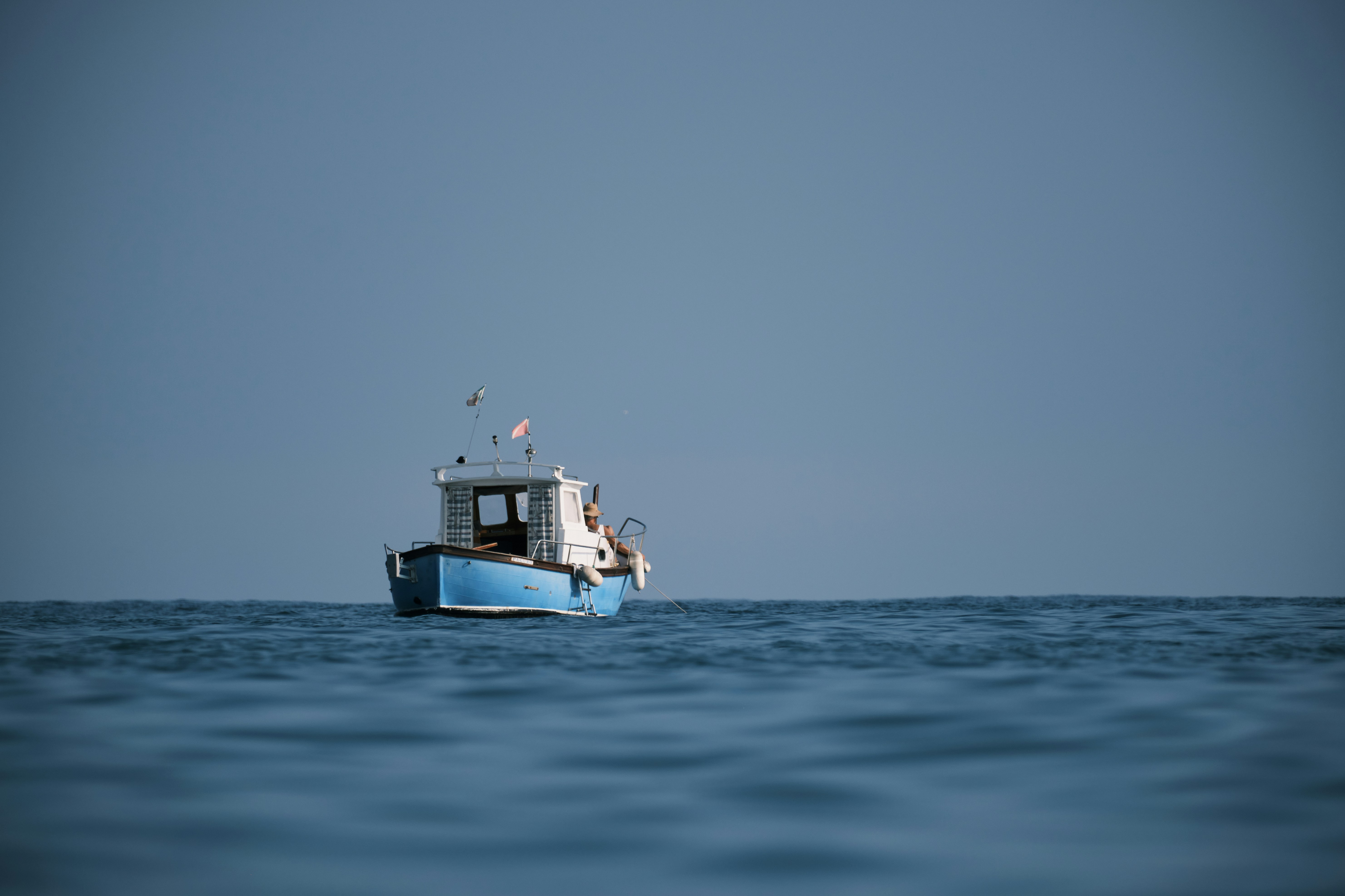 Foto Un pequeño bote en medio del océano – Imagen Italia gratis en Unsplash