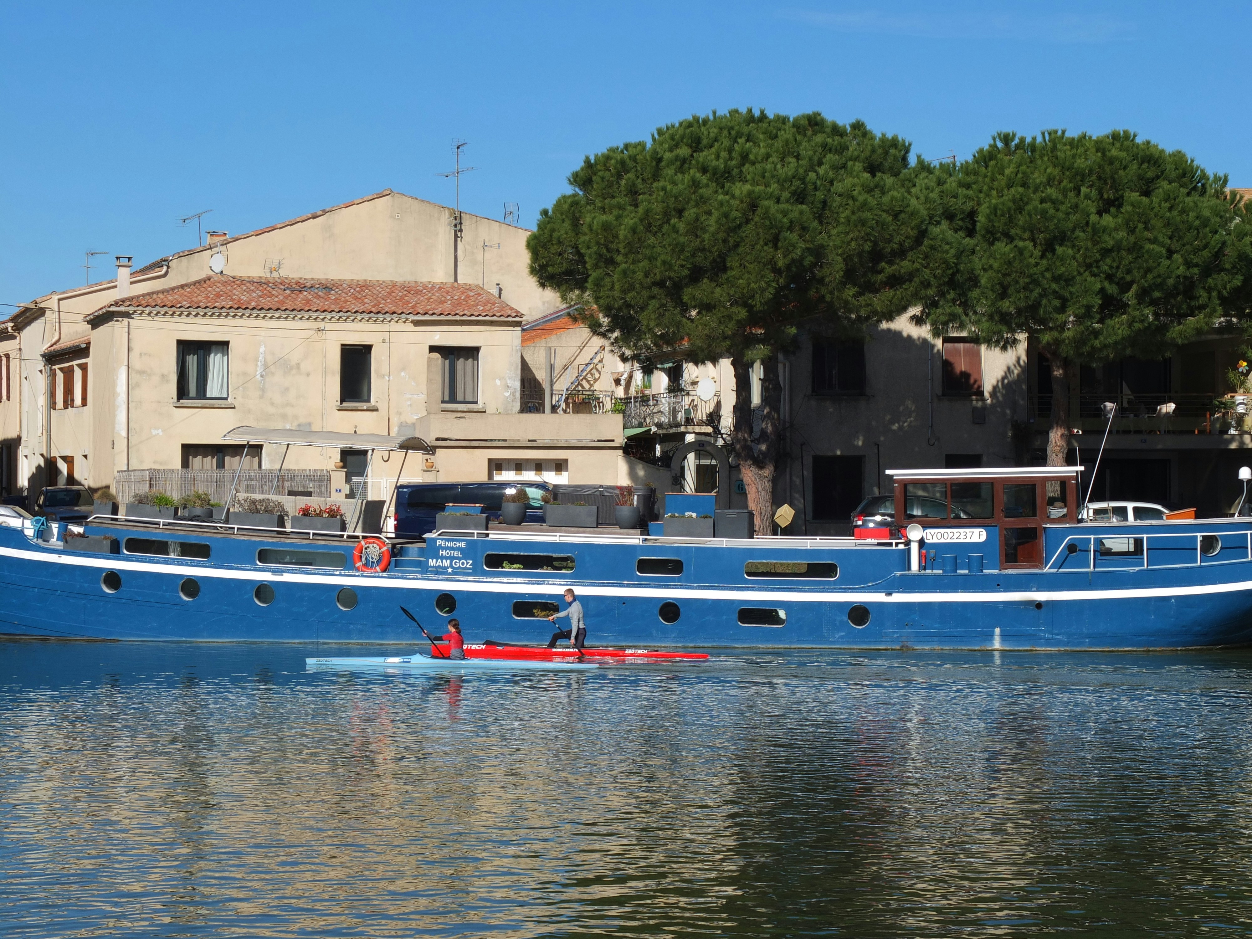 A blue boat floating on top of a body of water photo – Free home on ...