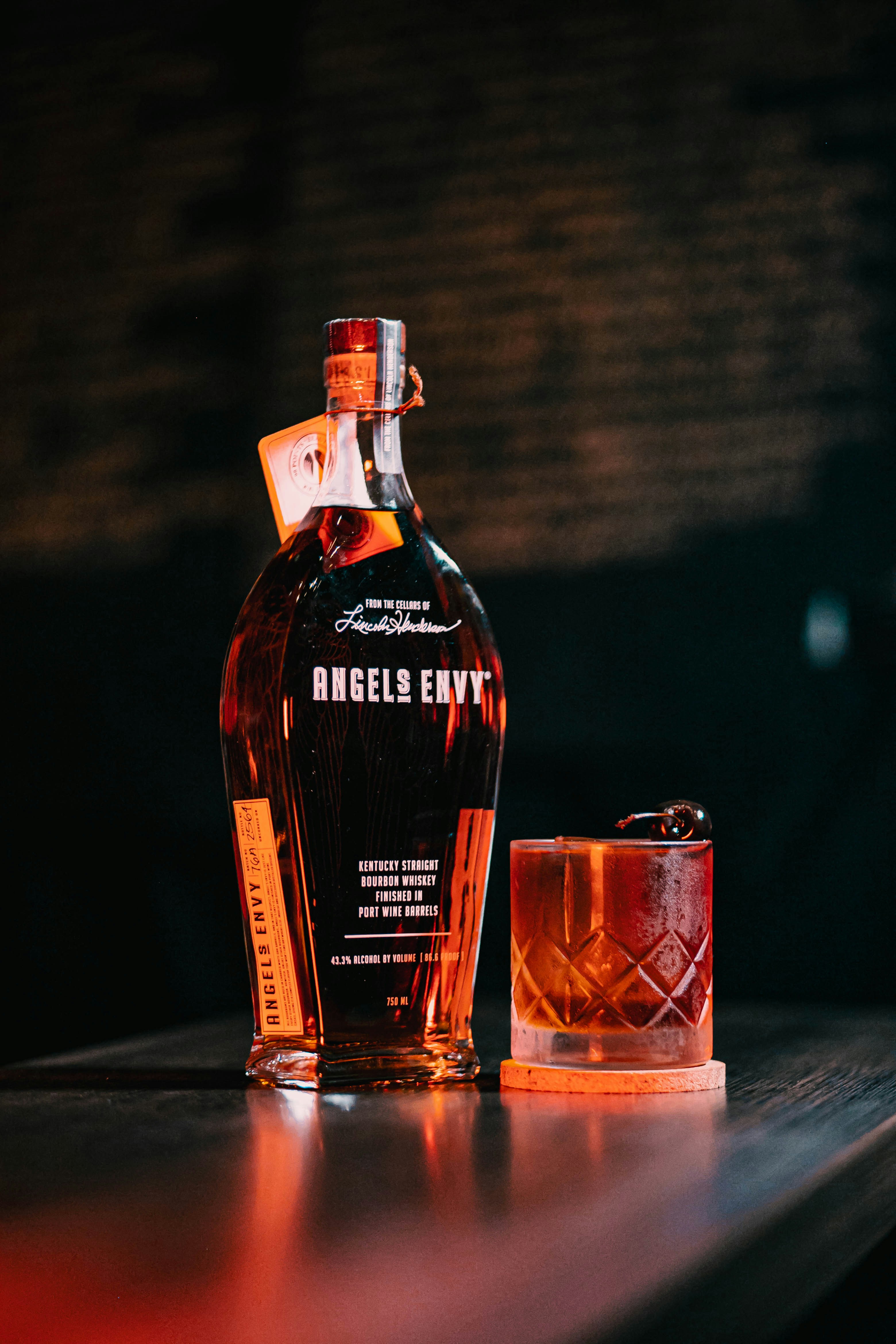 Una botella de Angel Envy junto a un vaso de chupito foto – Imagen de ...