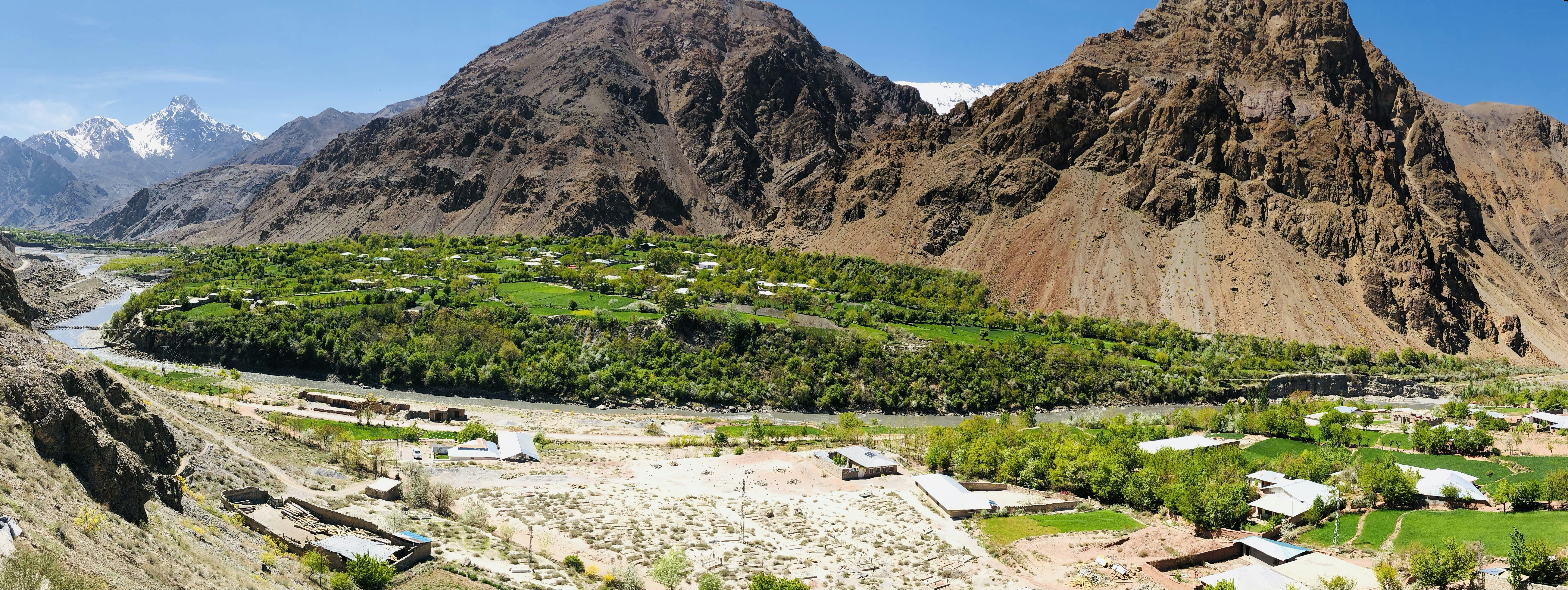 A valley surrounded by mountains with a river running through it photo ...