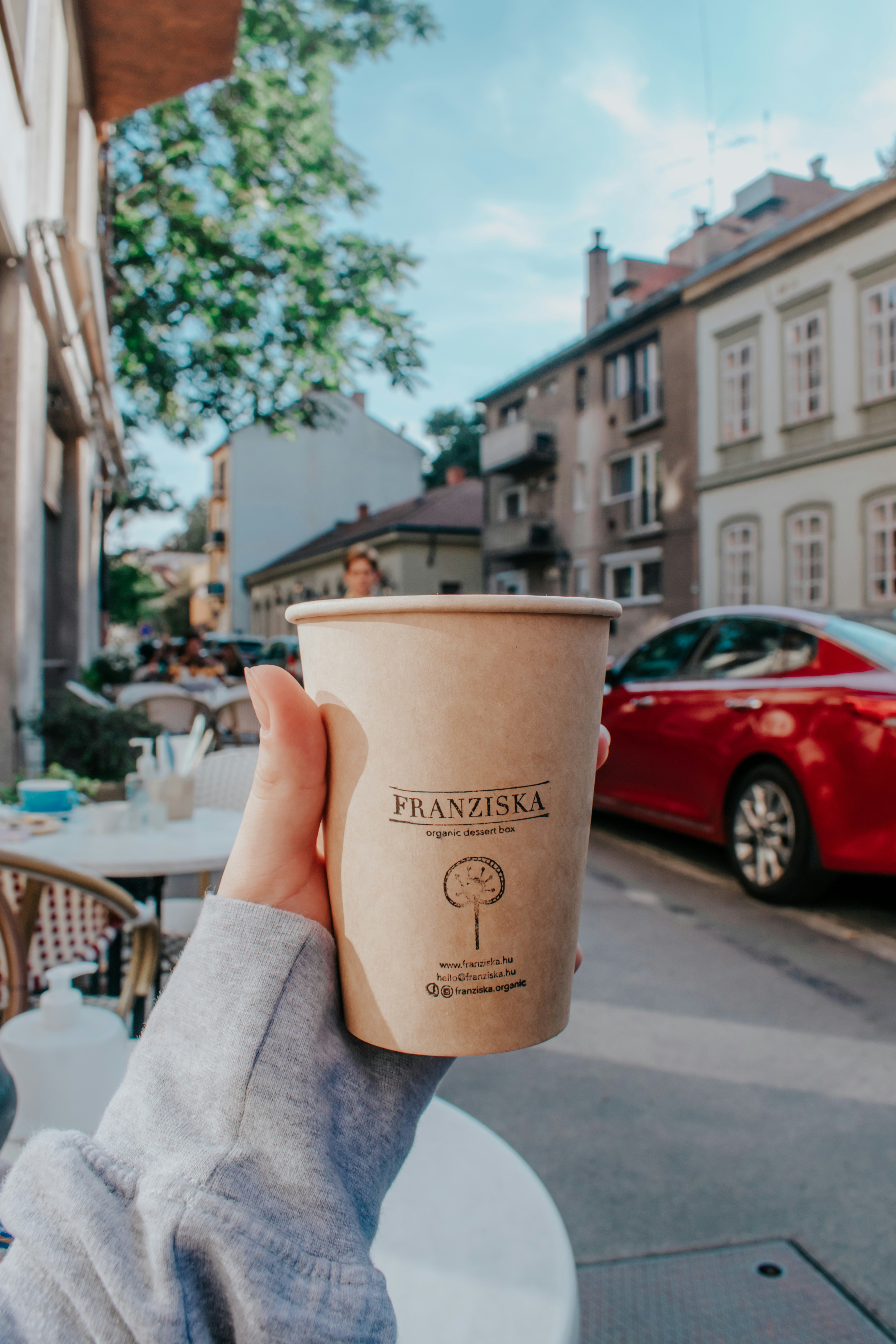 Franziska Cup in Focus: A Handheld Moment on a Sunlit City Street
