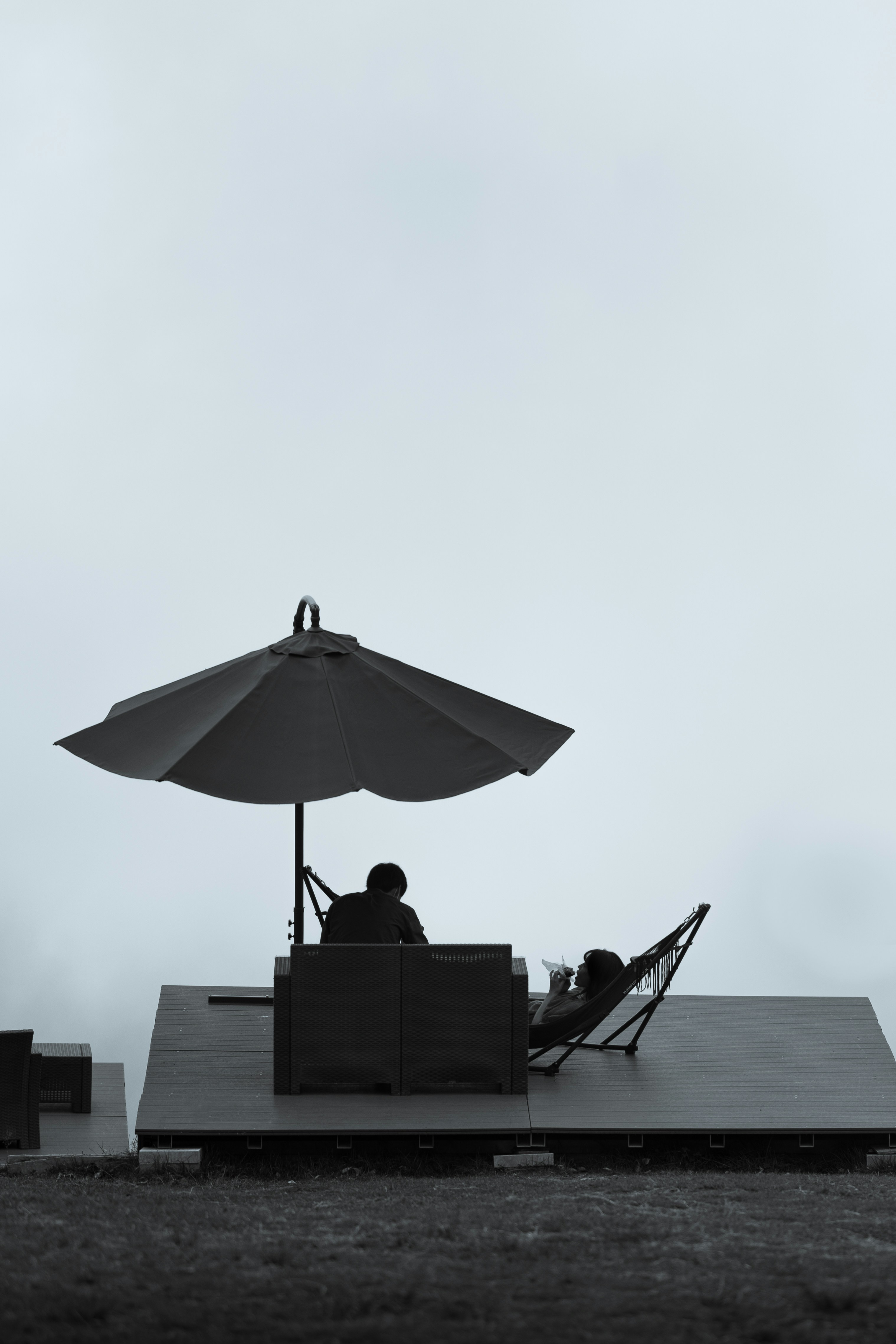 a couple of people sitting under an umbrella