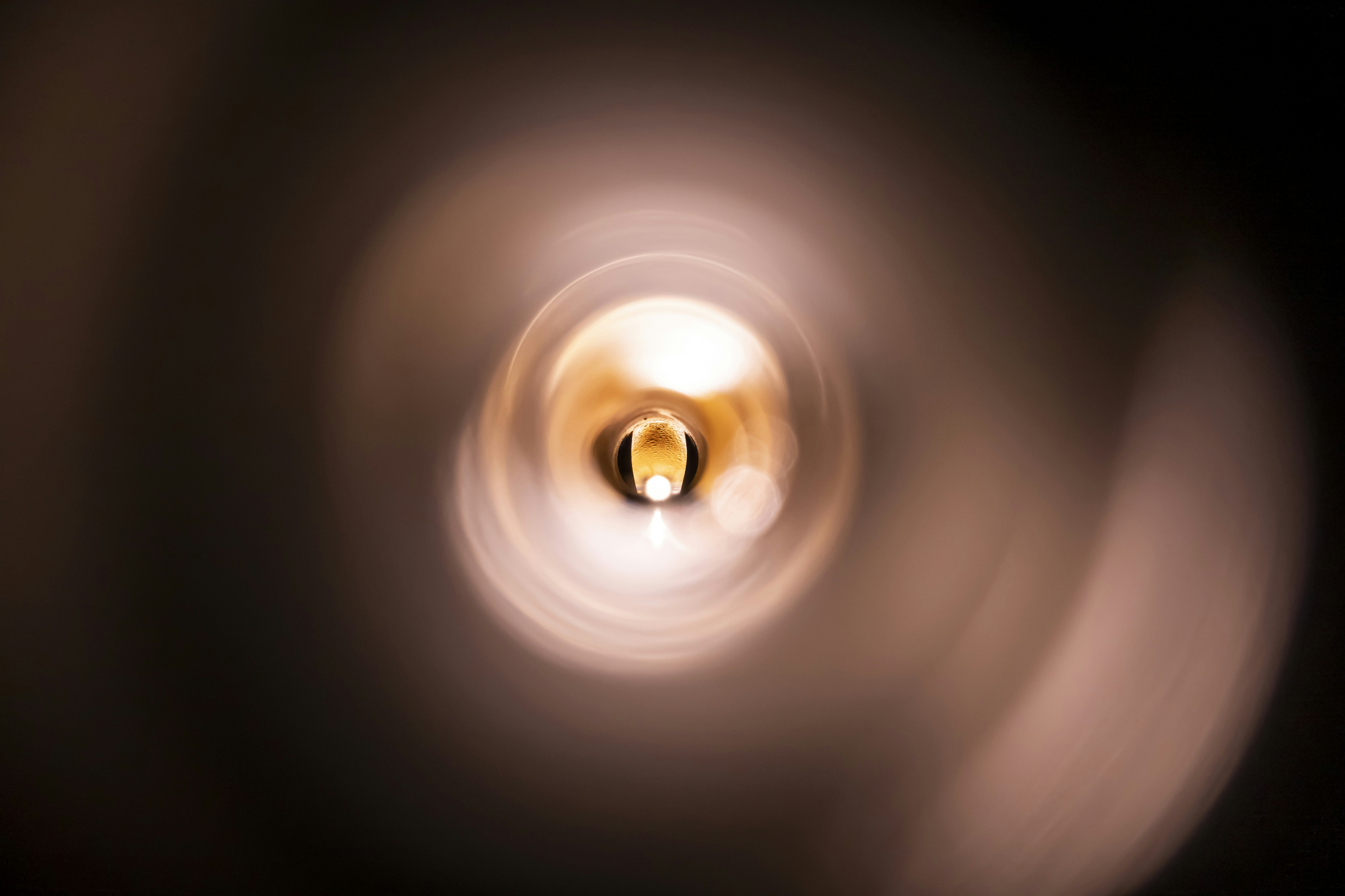 Warm light glowing at the center of a swirling abstract pattern.