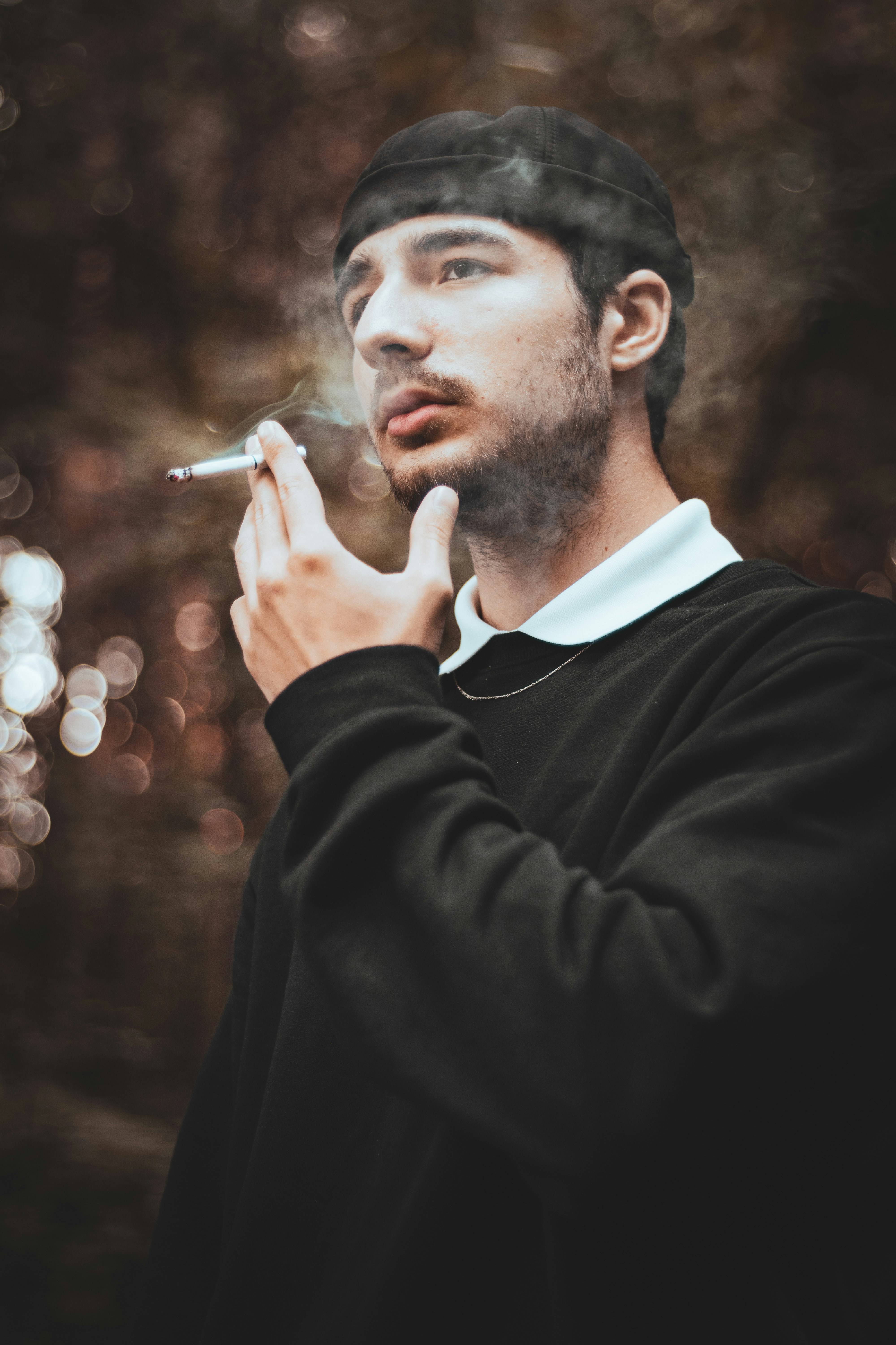 A man smoking a cigarette in a black jacket photo – Free Human Image on ...