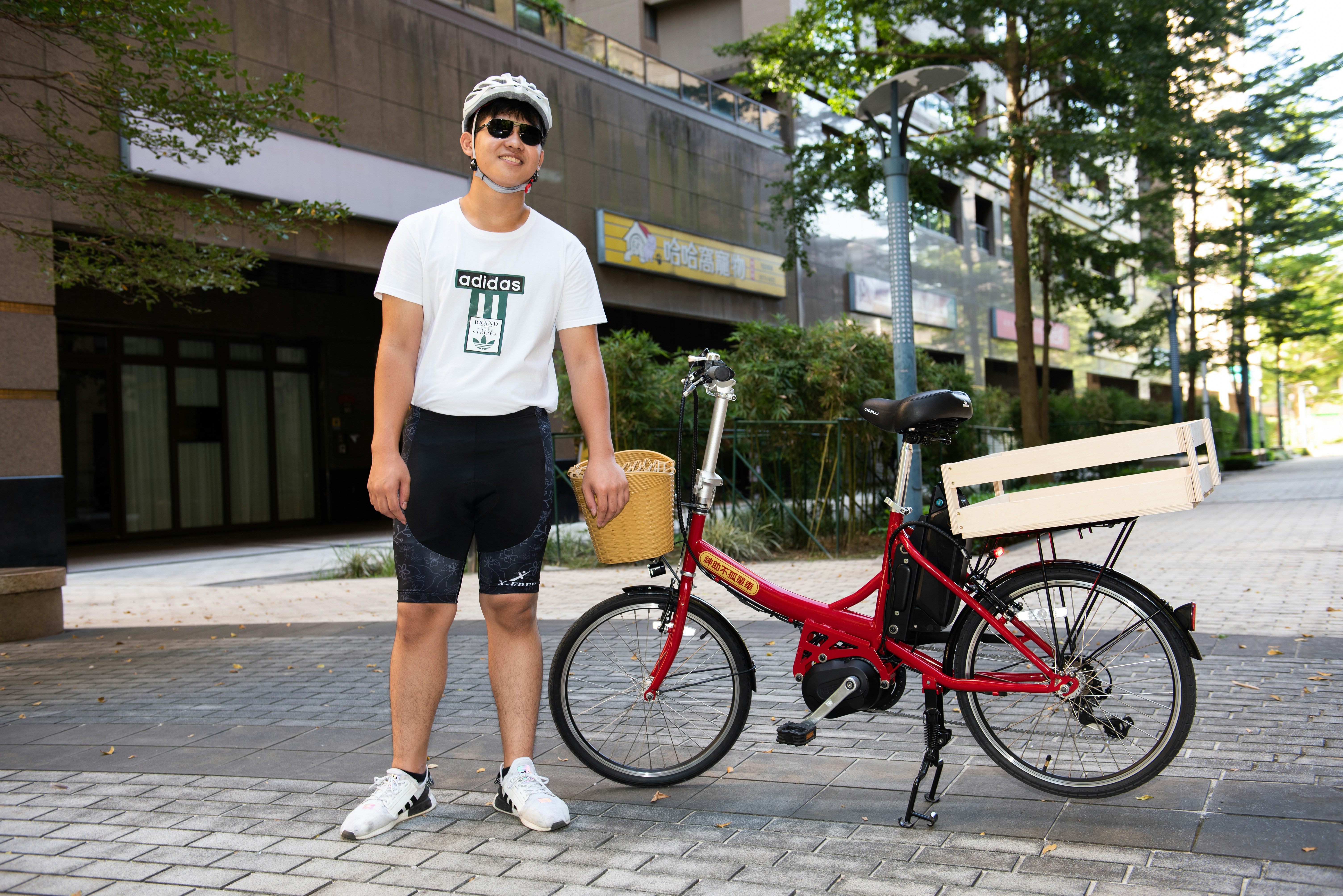 Sunlit stride beside a crimson cargo bike: a casual urban portrait