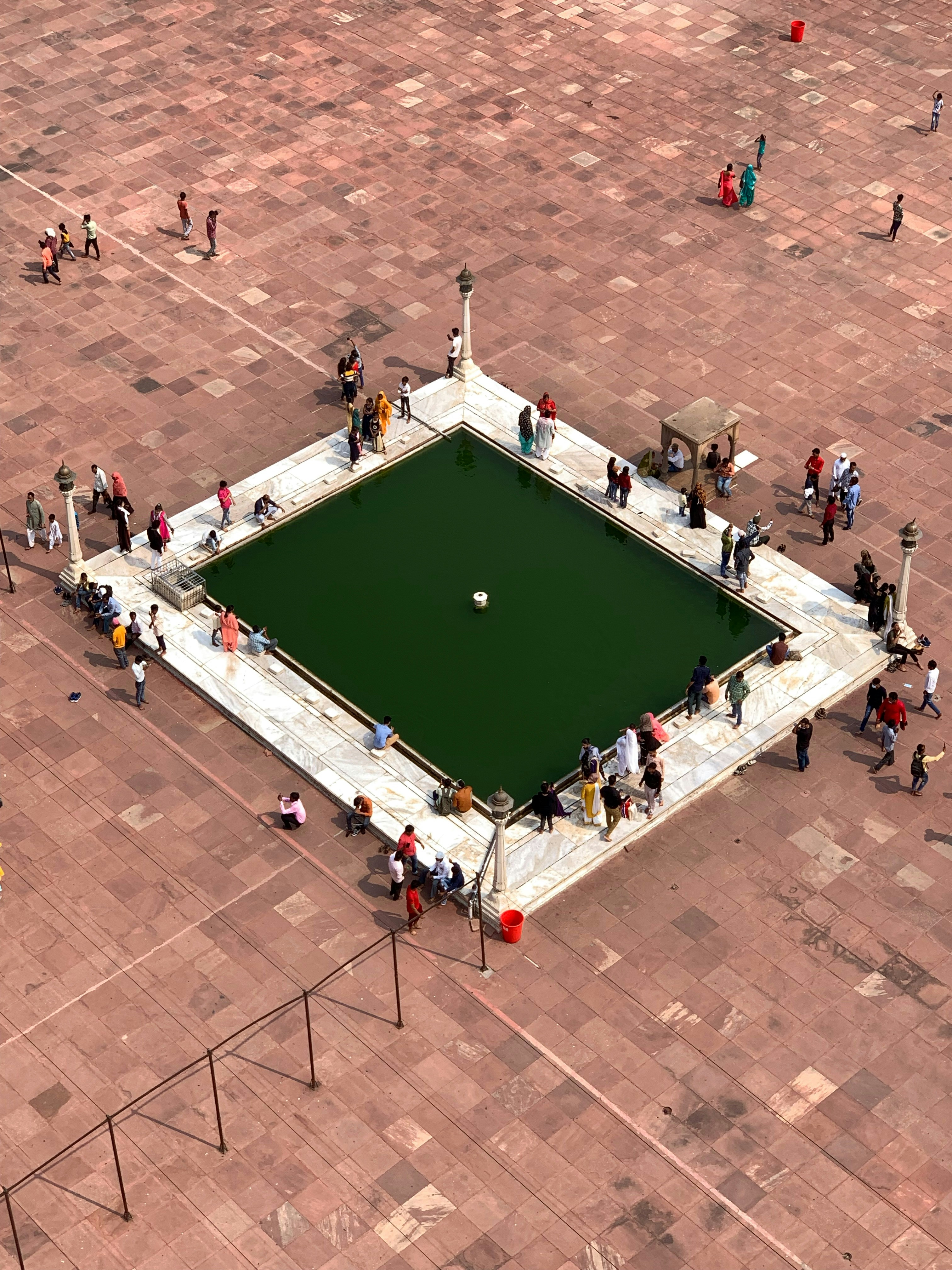 A group of people standing around a pool of water photo – Free Chandni ...