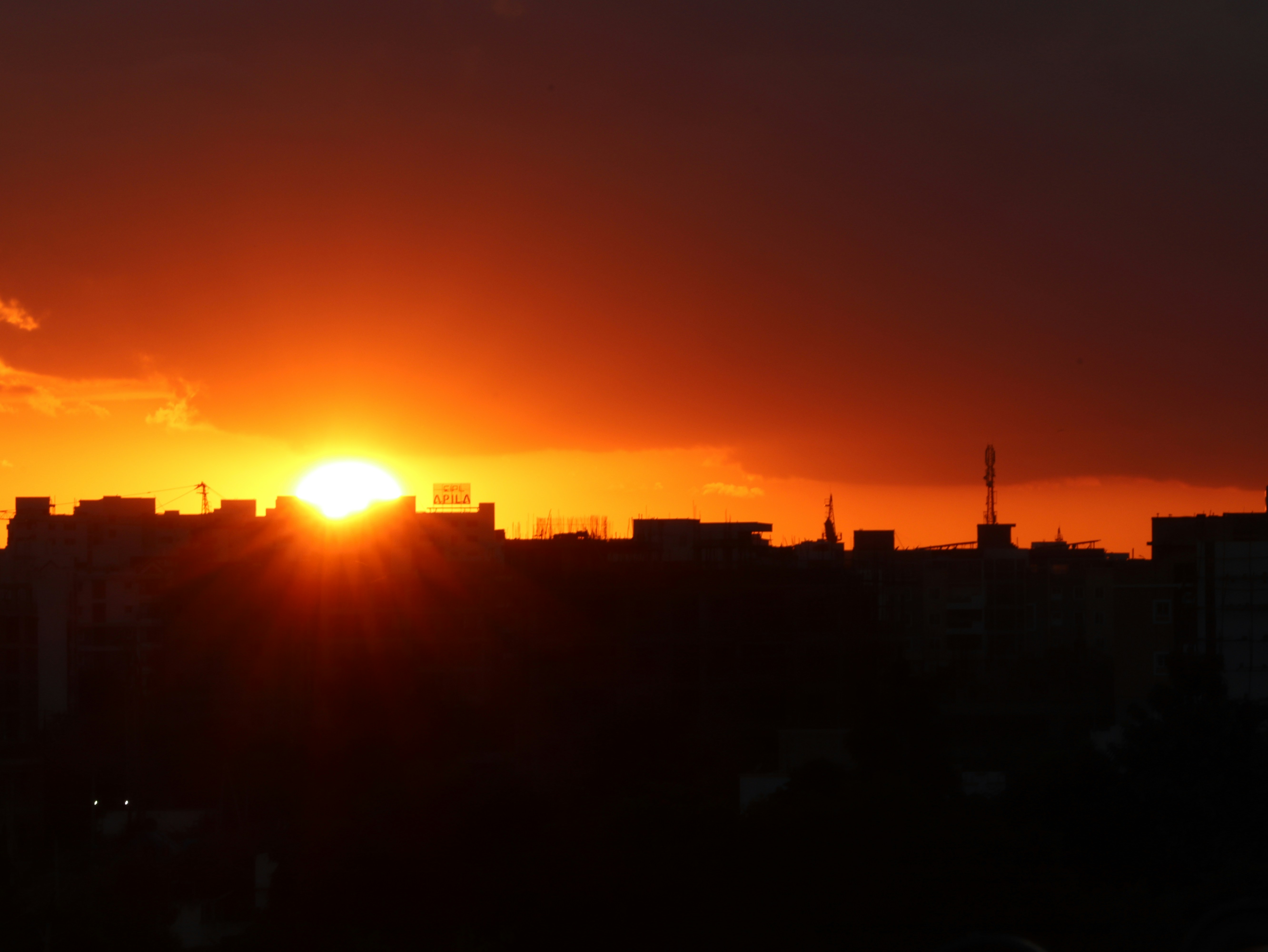 The sun is setting over a city with tall buildings photo – Free Nature ...