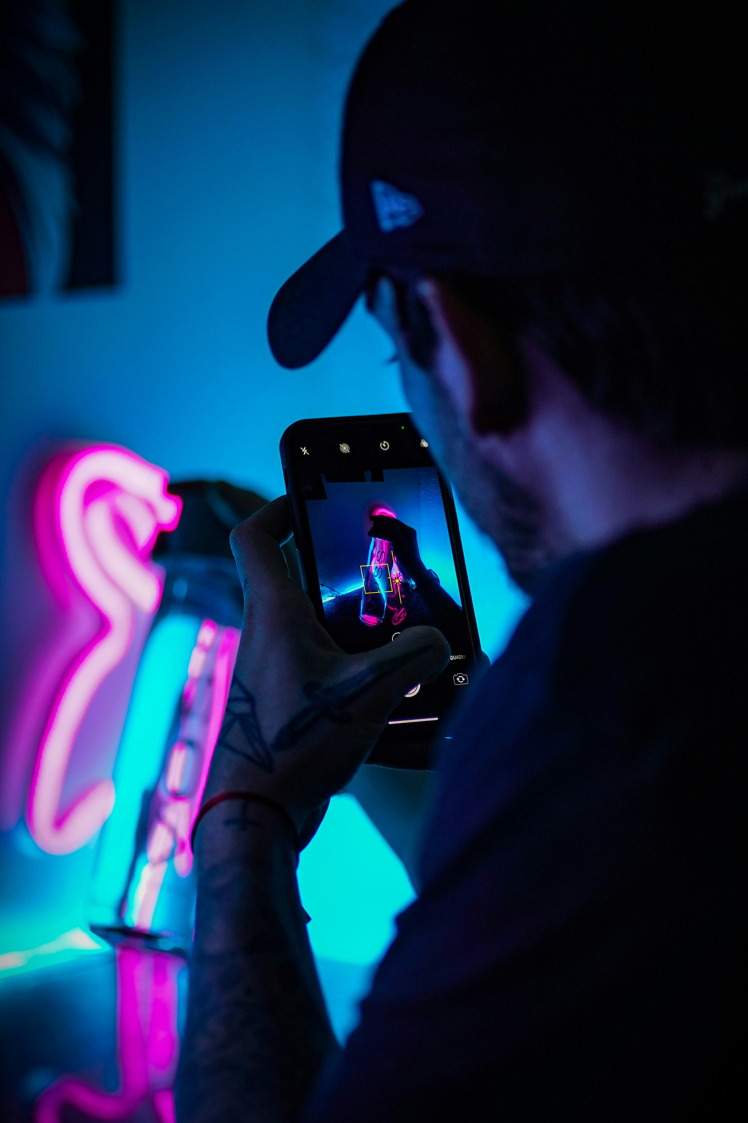 Neon Bottle Frame: A Night Shot Through a Handheld Phone