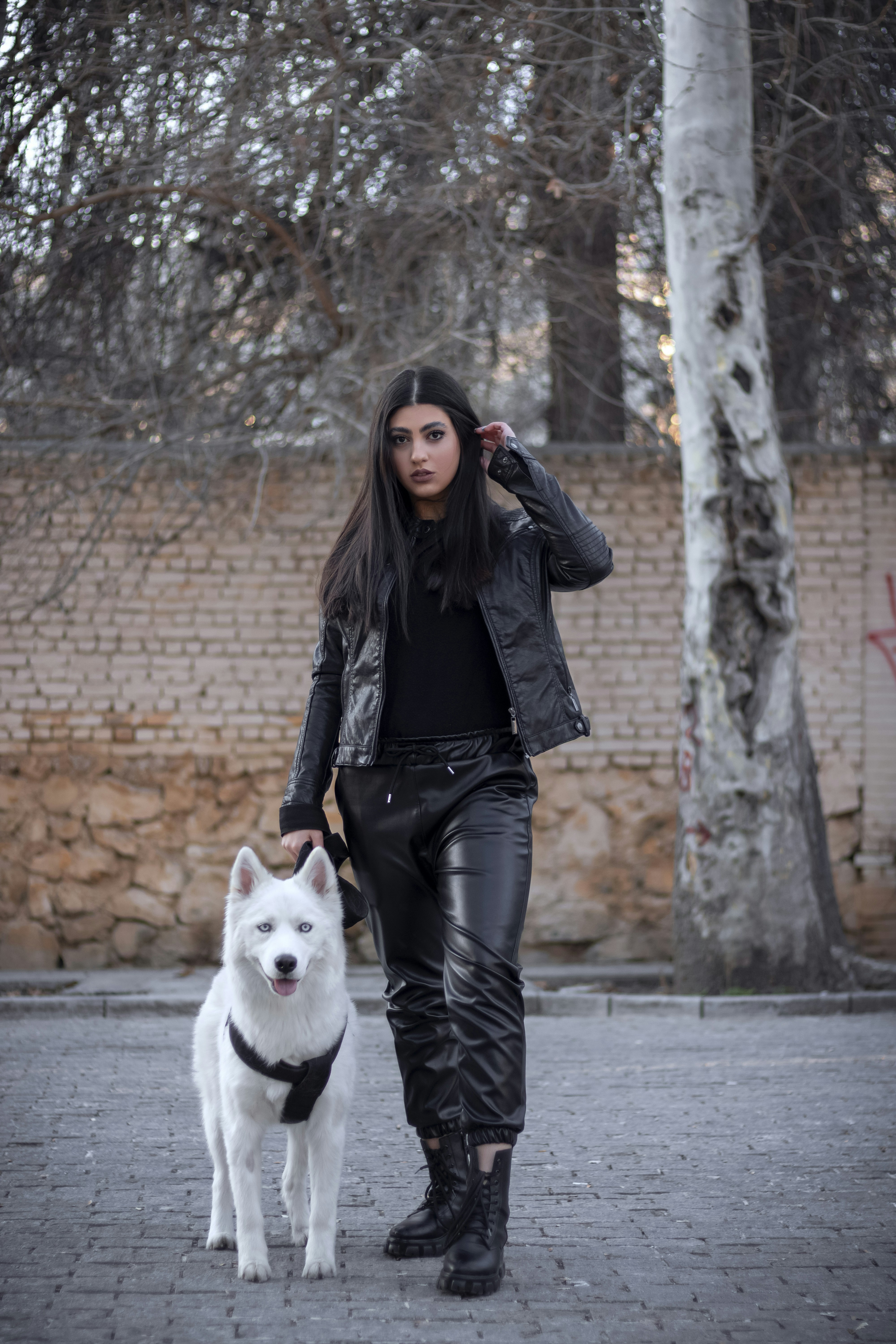 Urban stroll with a white companion: a confident duo against a brick backdrop