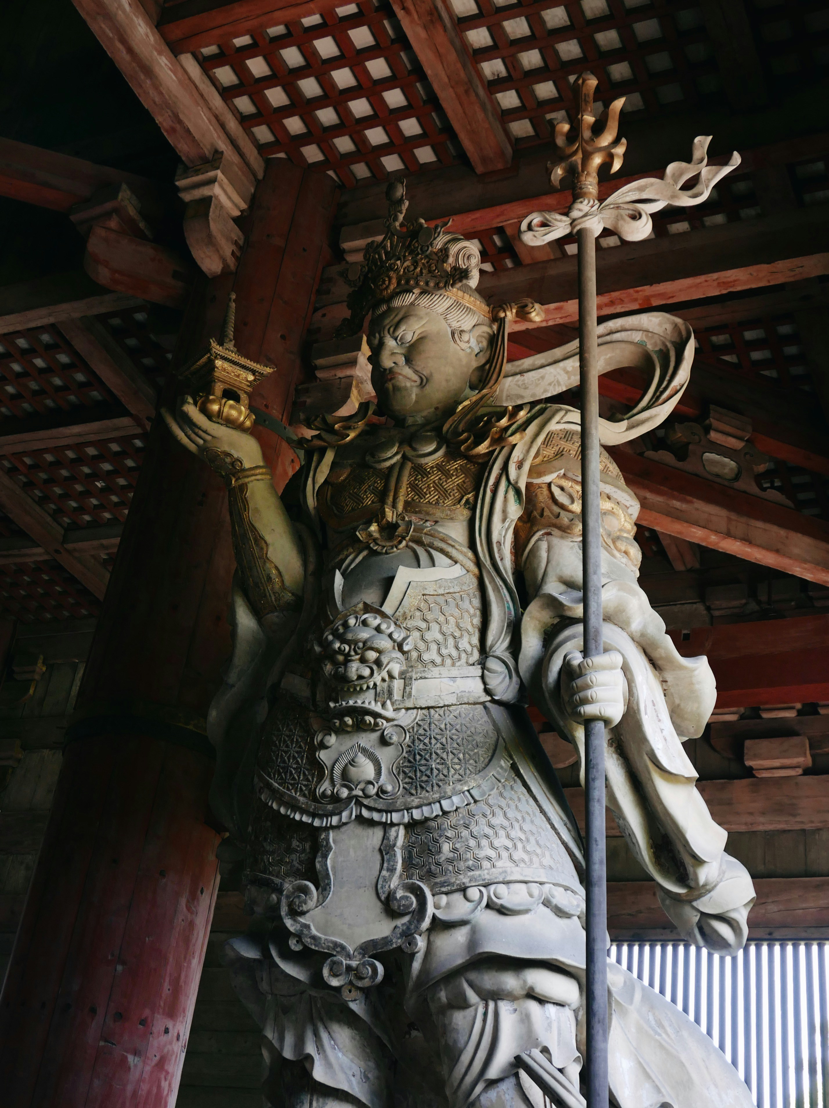 Temple Guardian in Stone: A Majestic Warrior Under Timbered Eaves