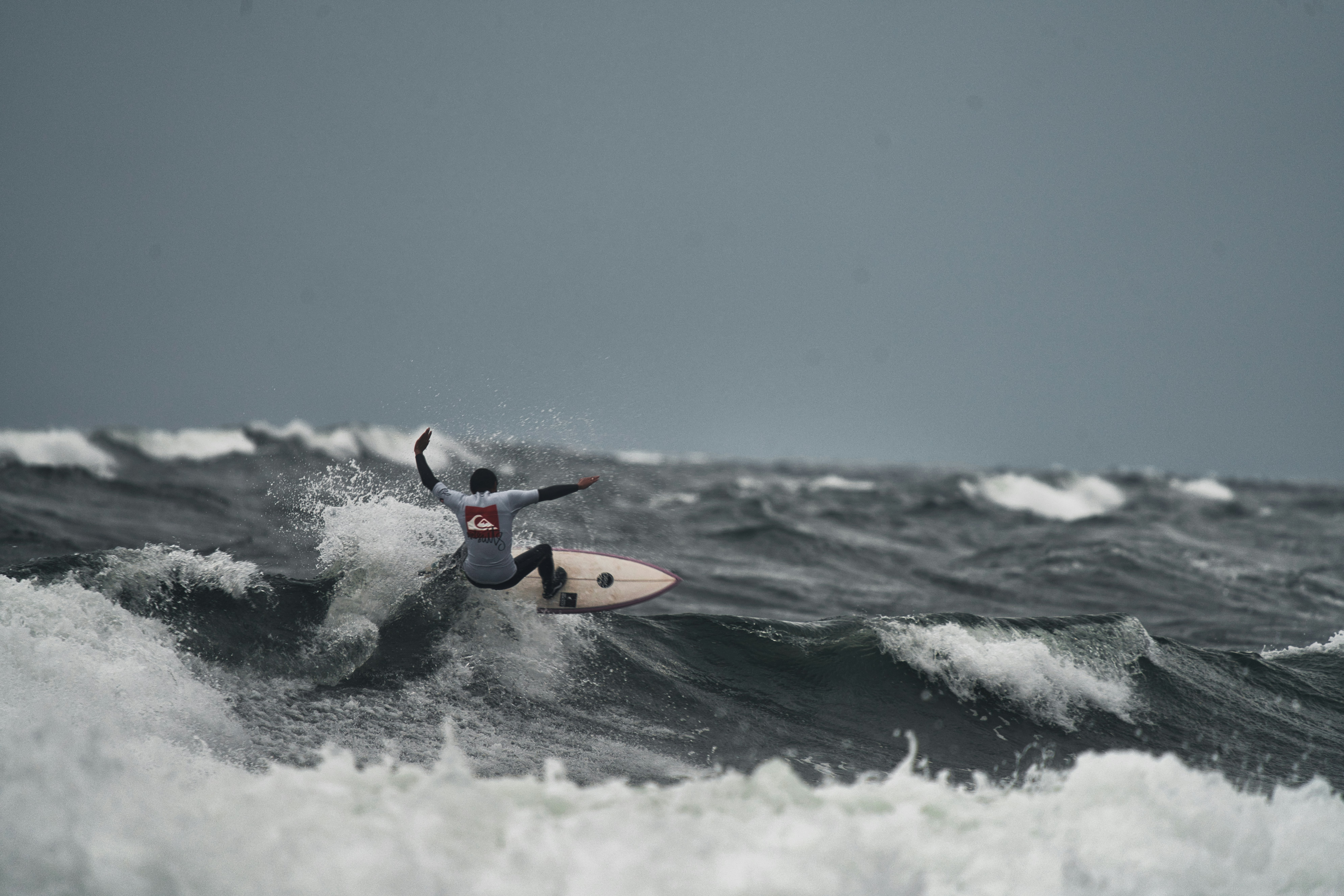 Un homme sur une planche de surf au sommet d’une vague dans l’océan ...
