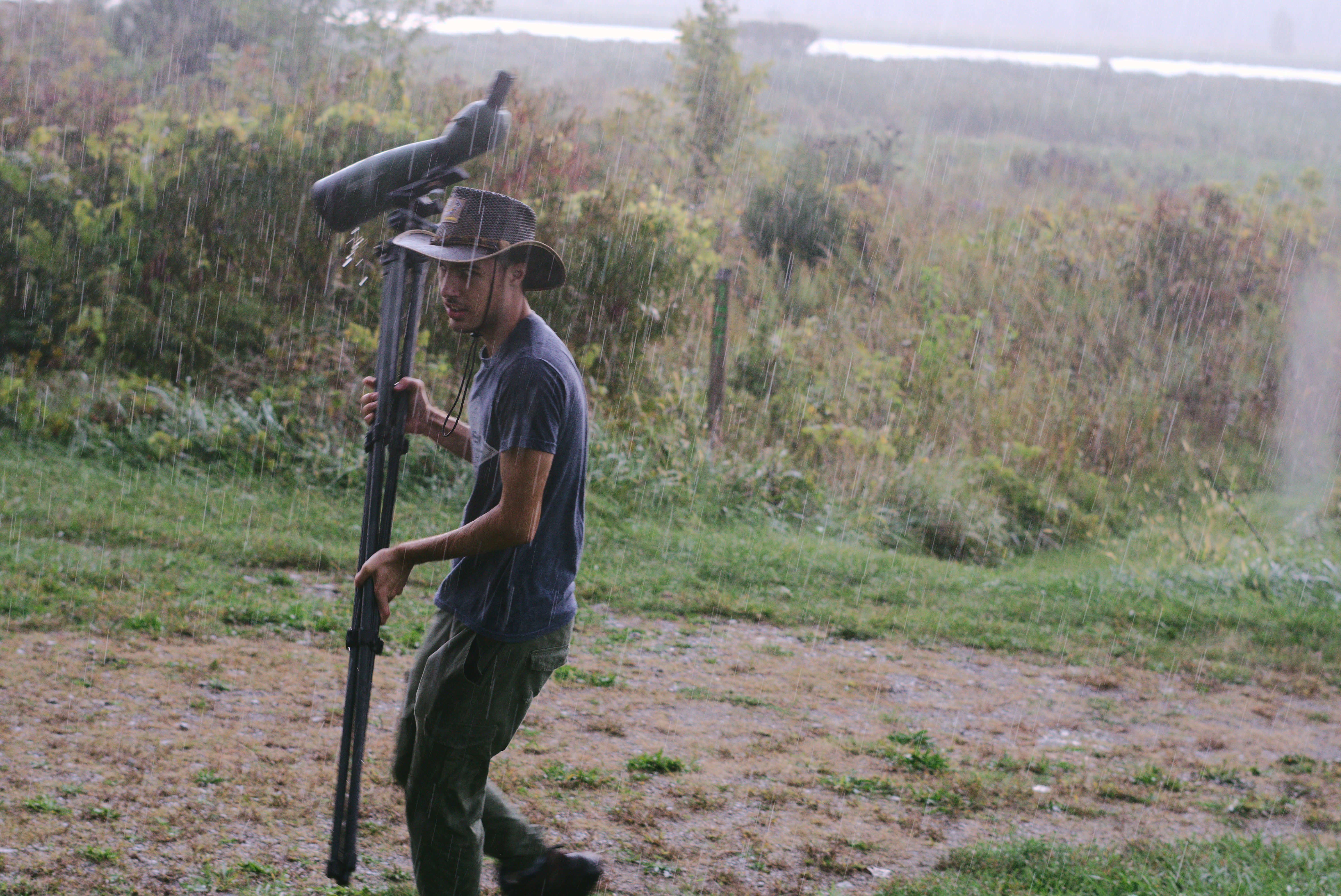 Harvest of Rain: A Fieldworker with a Tripod in a Misty Outdoor Scene