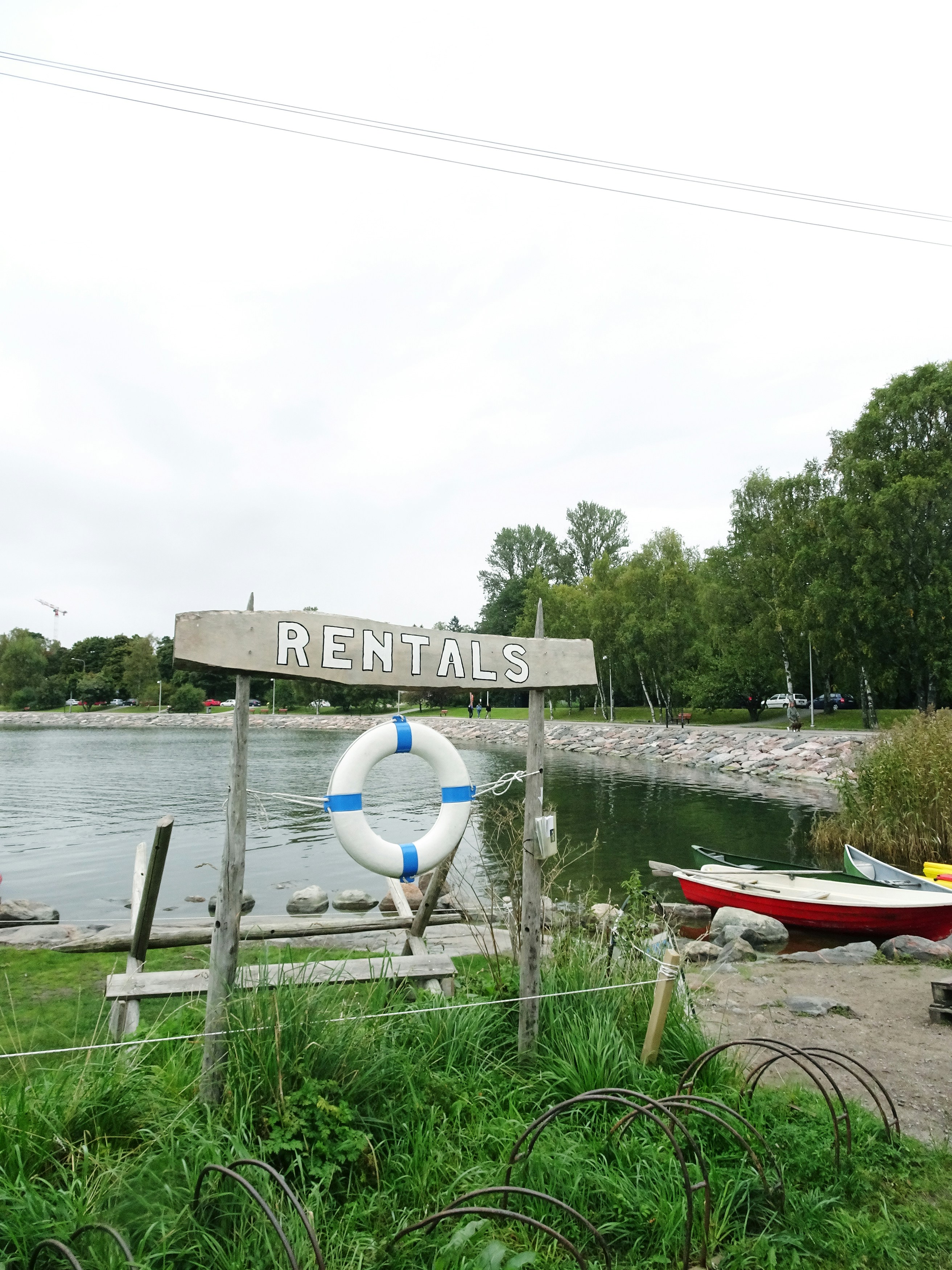 Weathered Rentals Sign by the Lake, Framed by a Blue Lifebuoy