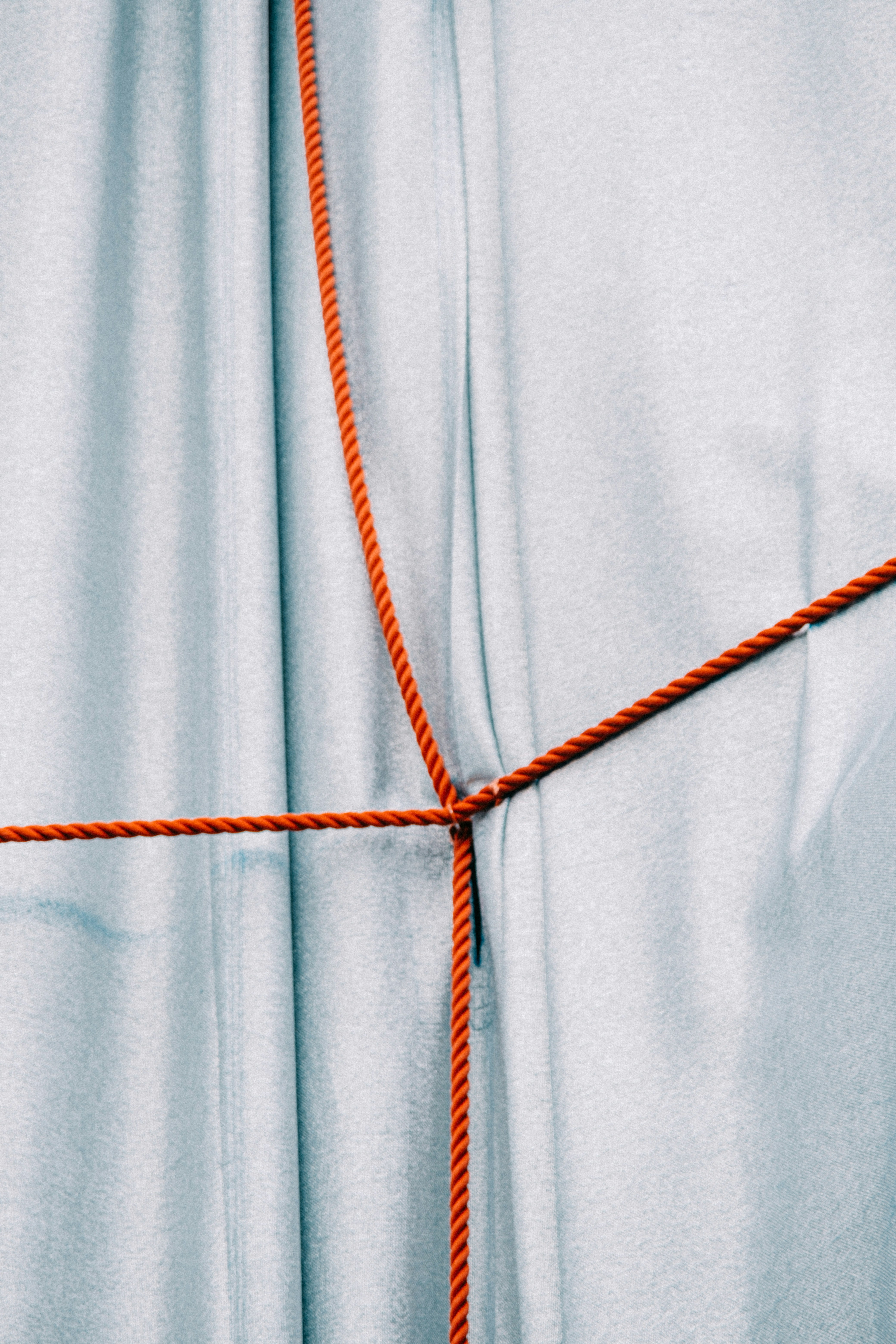 A close up of a piece of orange rope tied to a curtain photo – Free ...