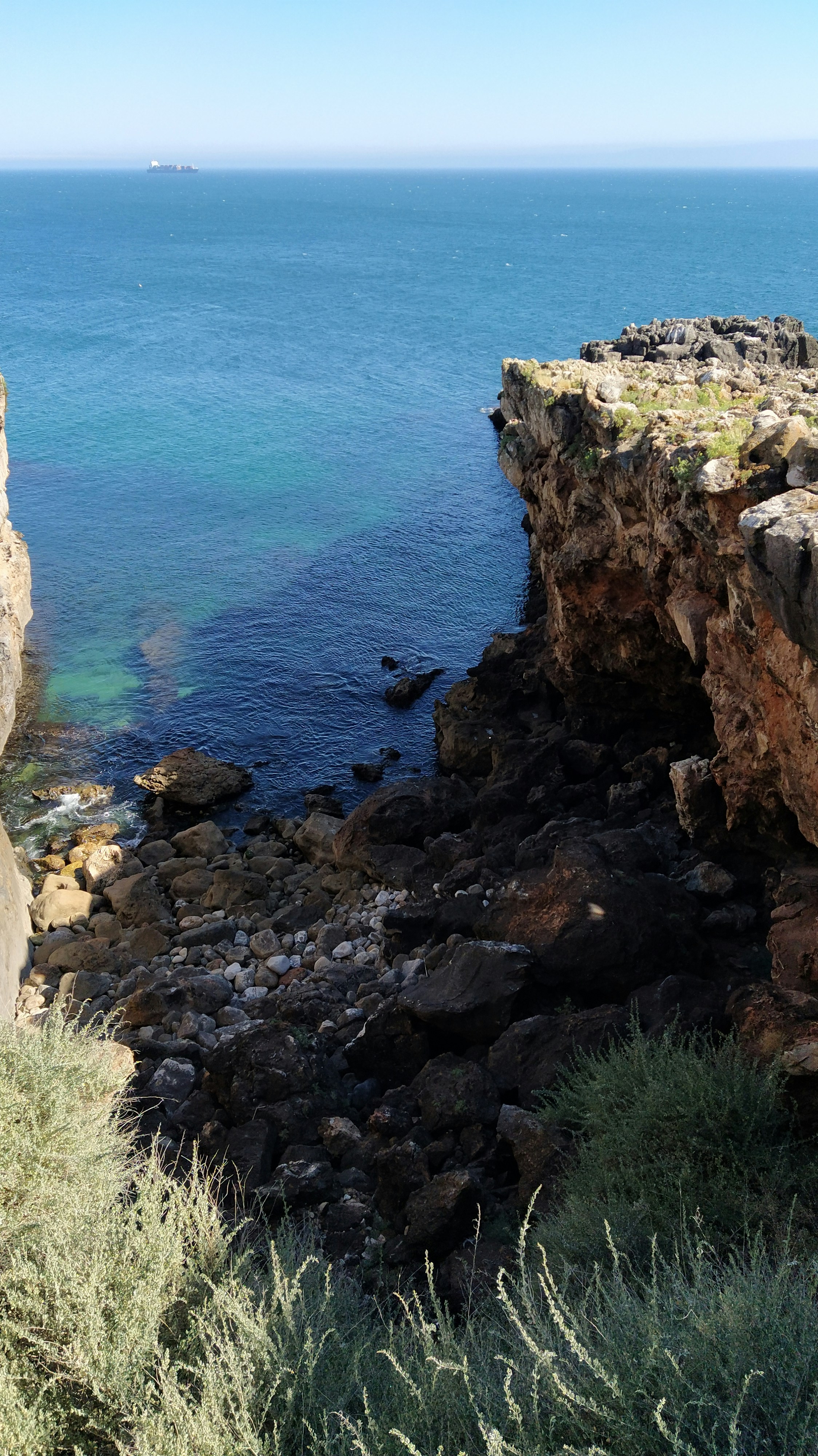 Foto Un acantilado rocoso con un cuerpo de agua en el fondo – Imagen ...