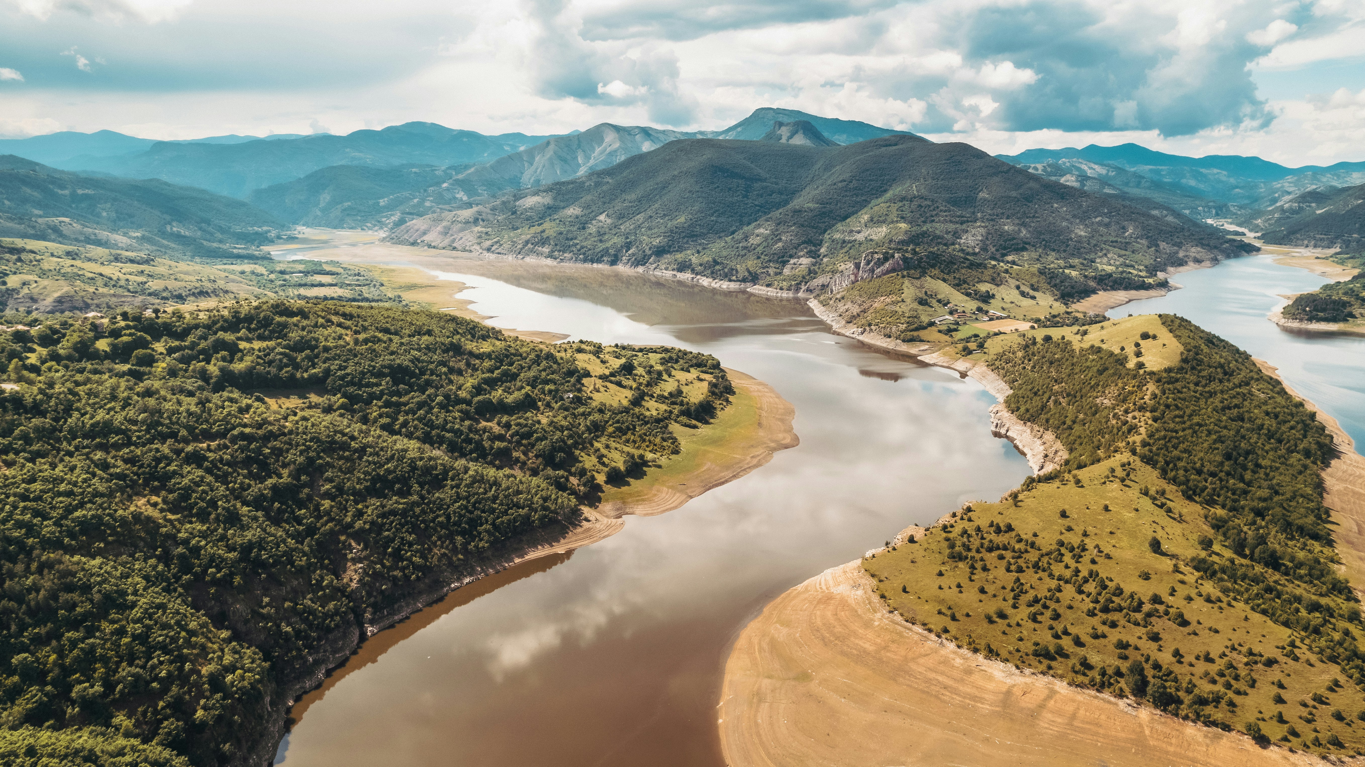 An aerial view of a river surrounded by mountains photo – Free ...