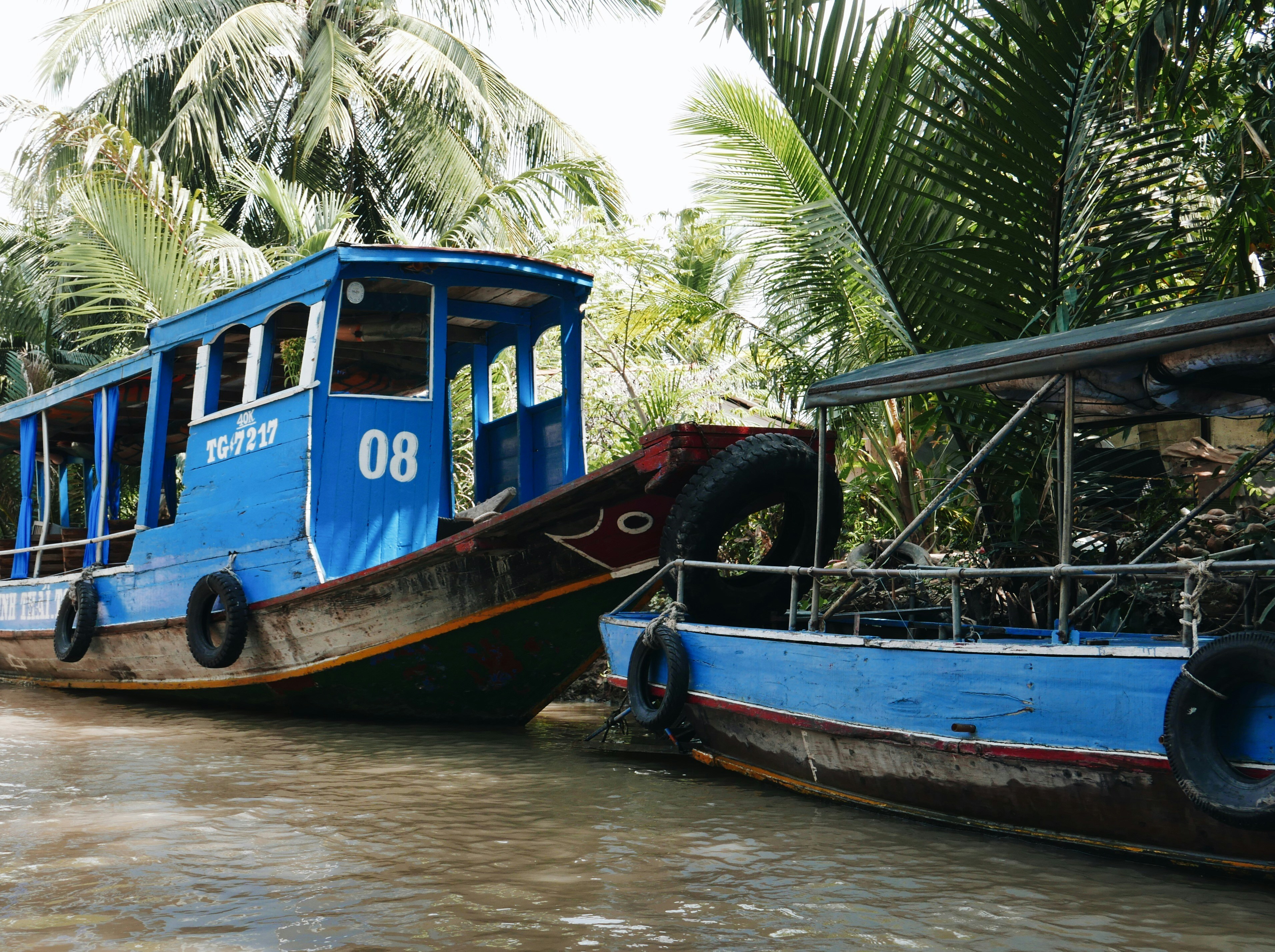 Foto Un par de botes que están sentados en el agua – Imagen Vietnam ...