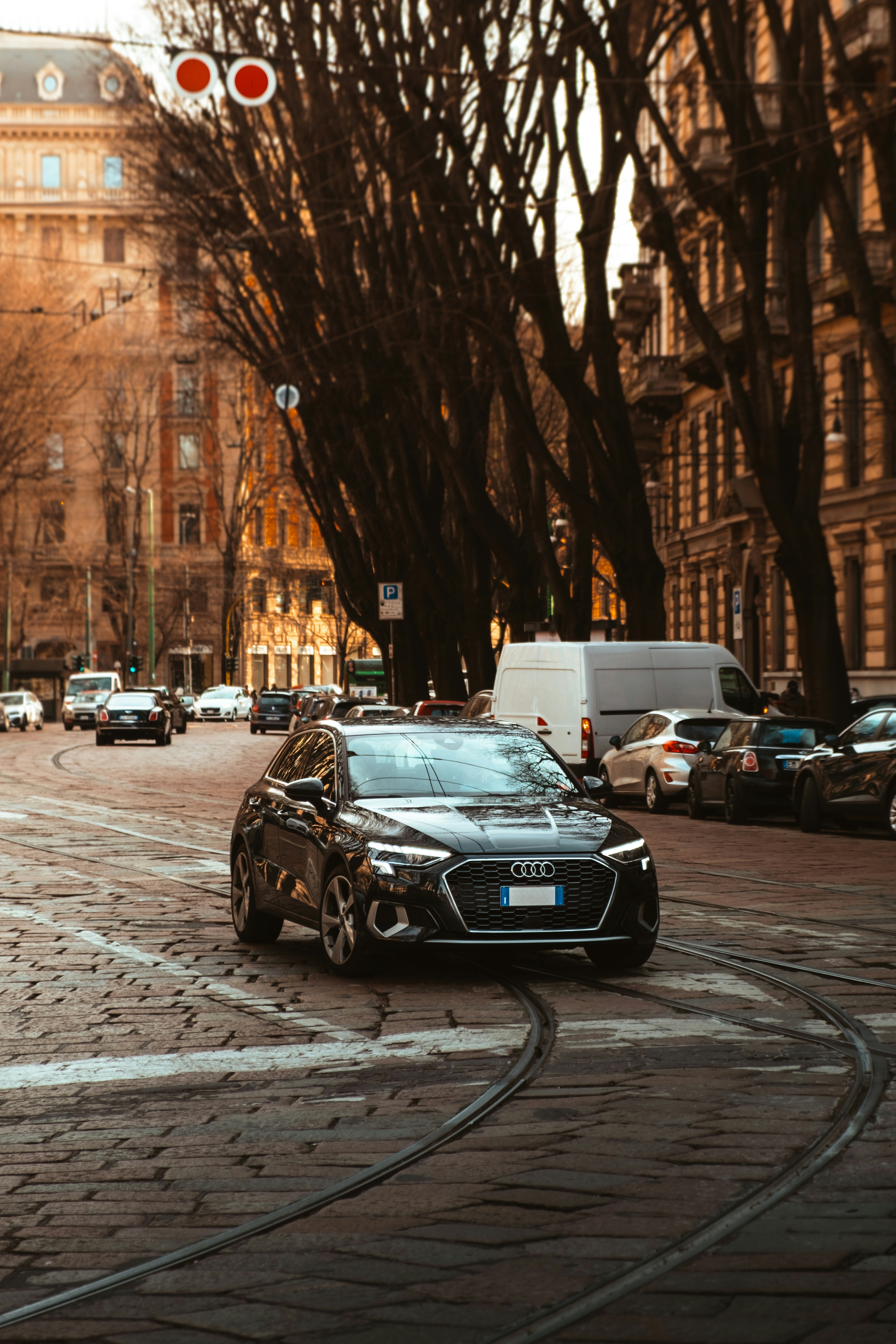 Audi at the Bend: Cobblestones, Rails, and Golden-Hour Glow