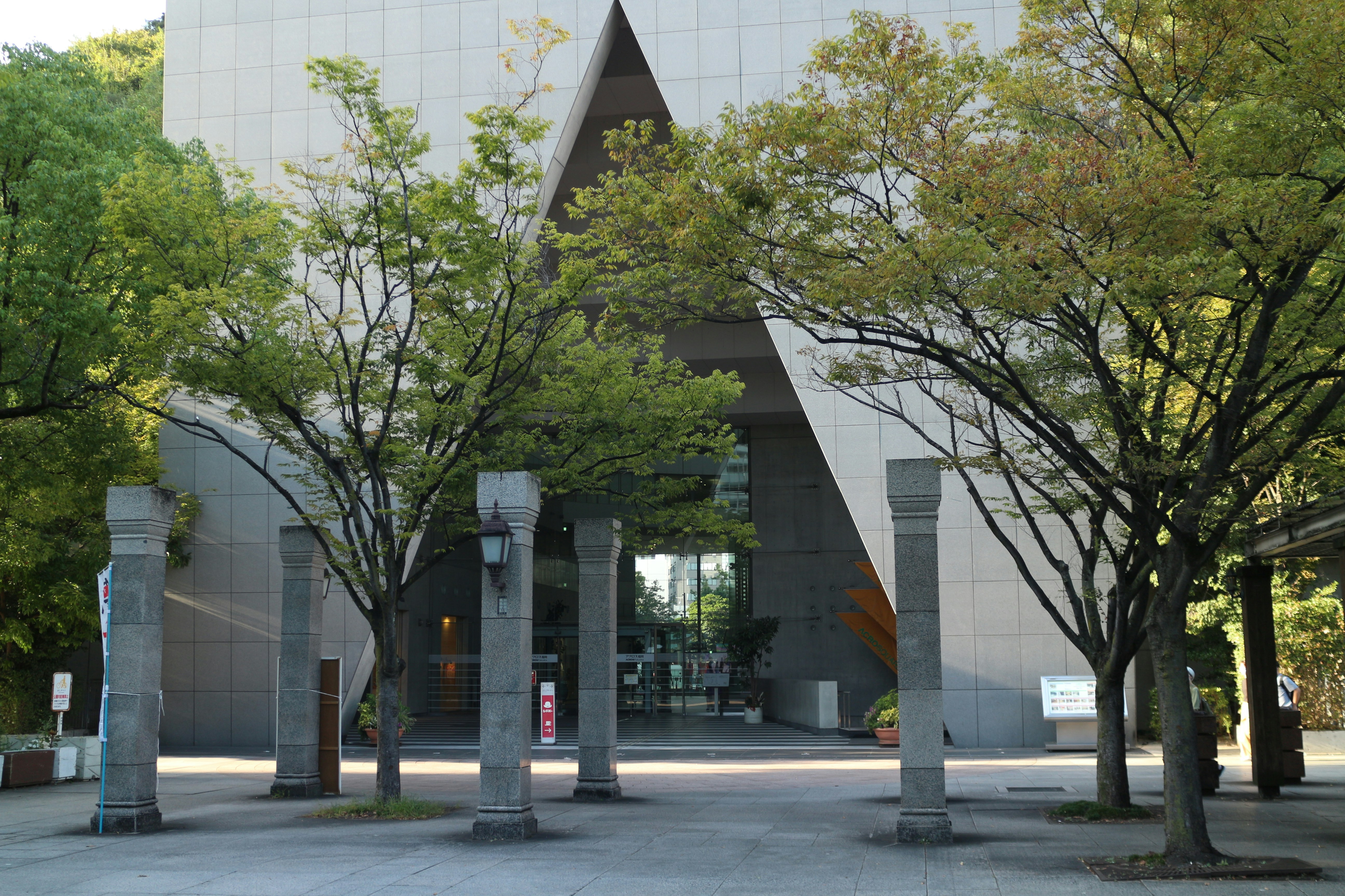 A building with a triangle shaped entrance surrounded by trees photo ...