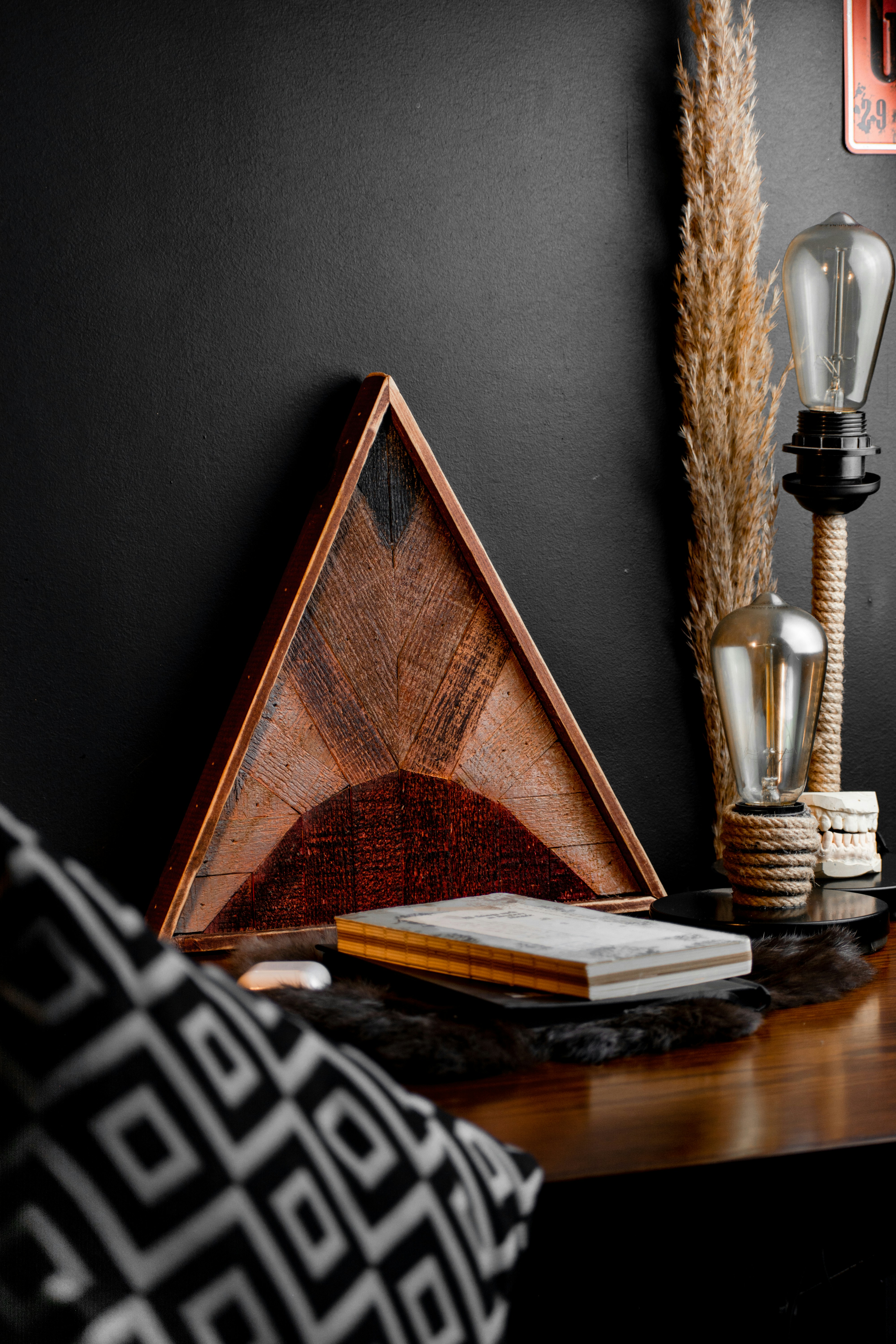 Geometric Woodwork and Vintage Lighting on a Dark Mantel