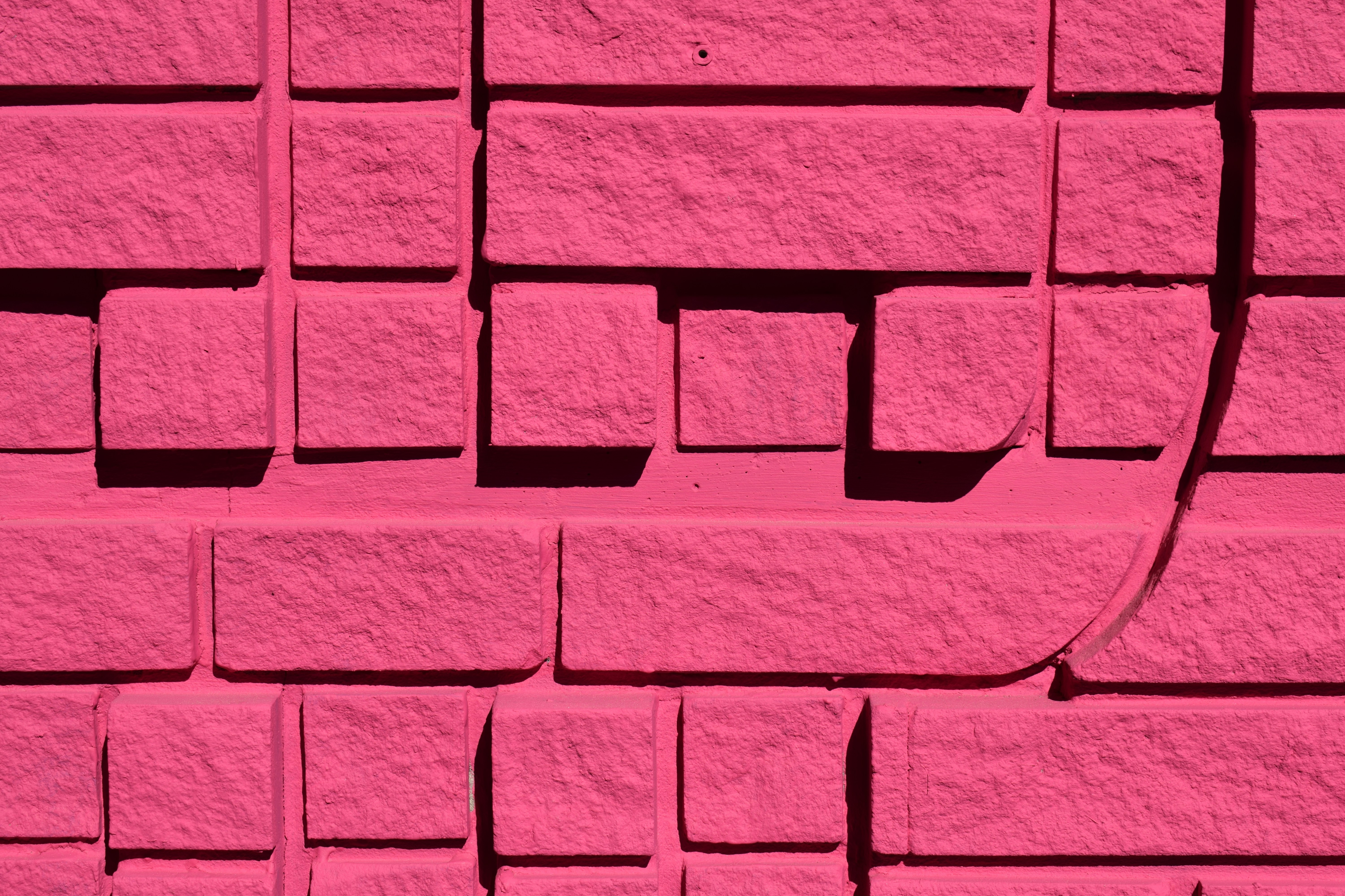 Neon Pink Brickwork: Close-Up of a Curved Edge and Rectangular Texture