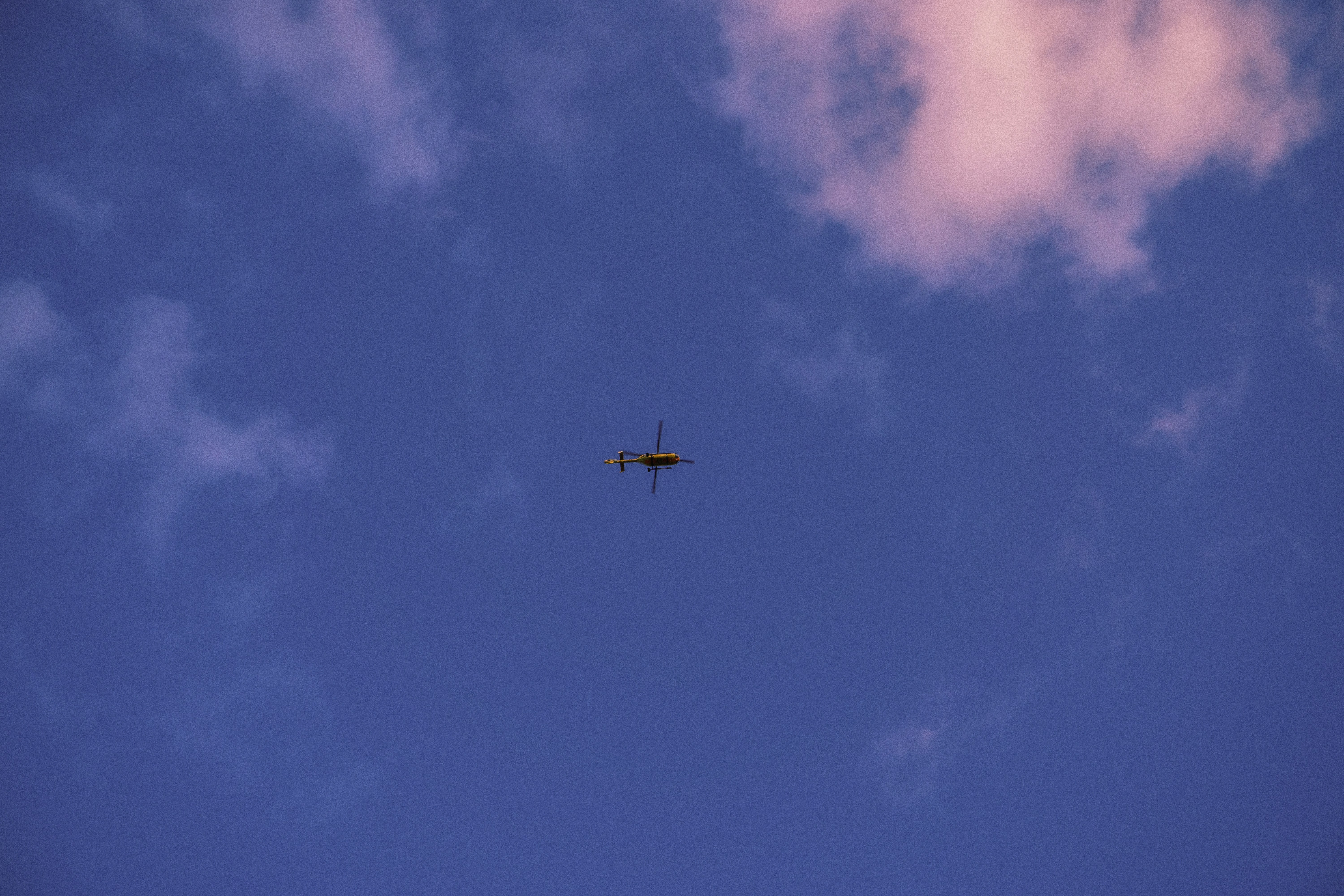 Lone Plane Across an Azure Sky with Rosy Clouds