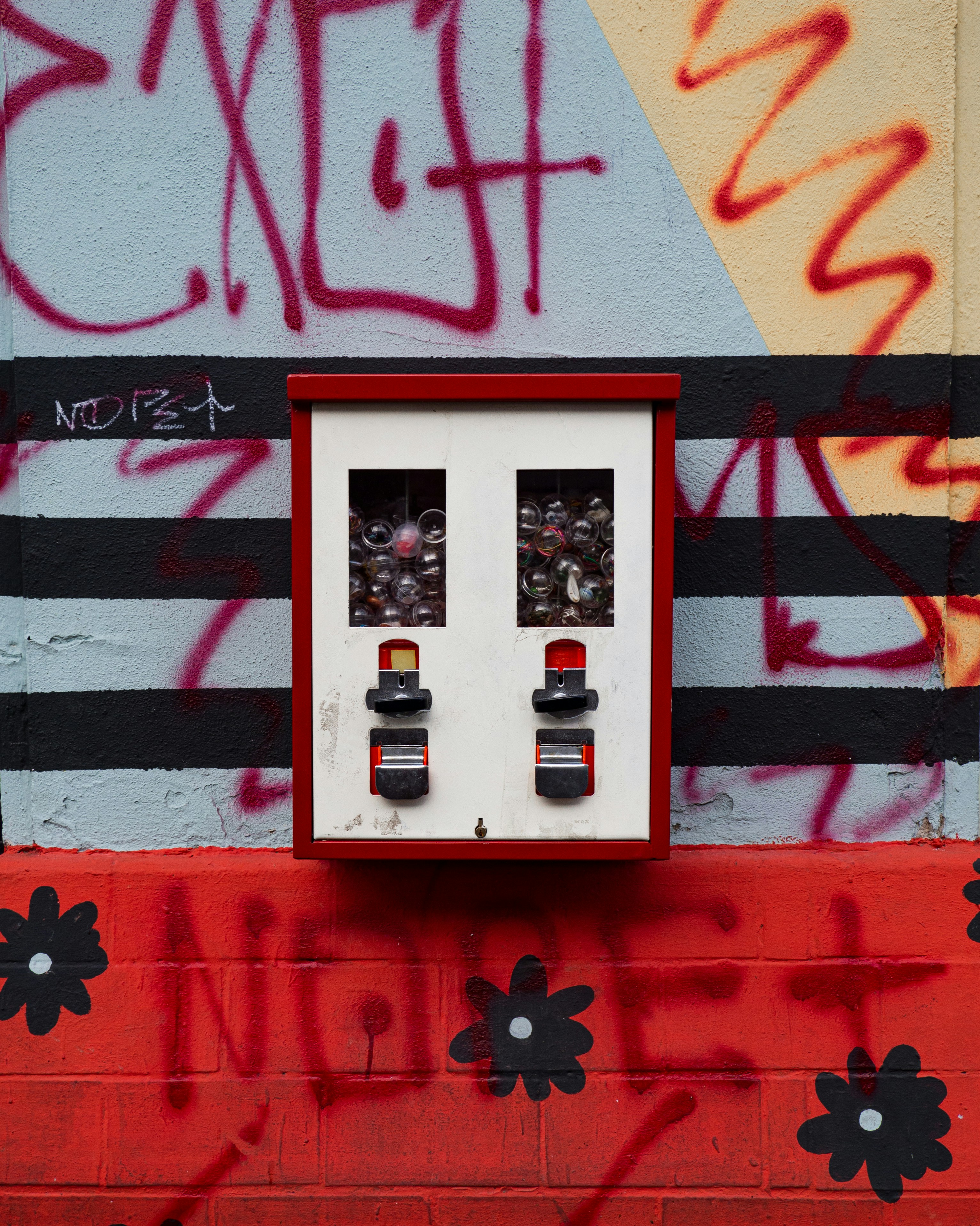 Red Vending Box Anchored by Striped Graffiti